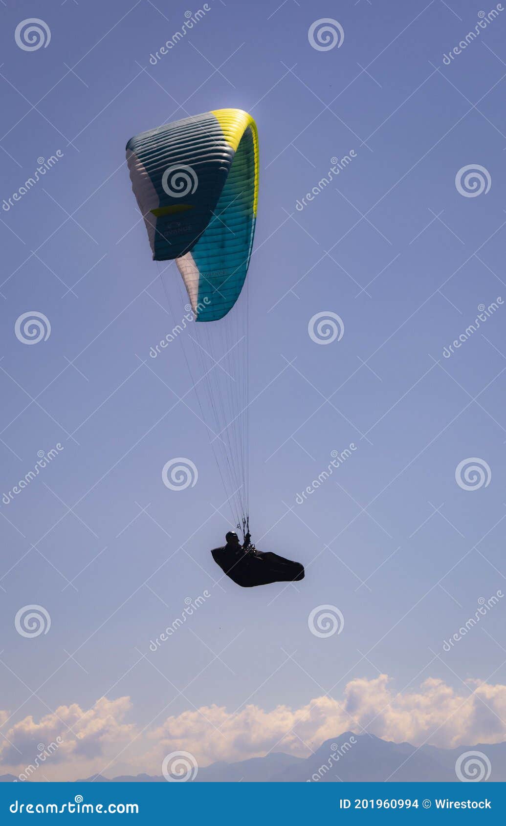 Vertical Shot of a Person Parasailing High in the Sky Stock Photo ...