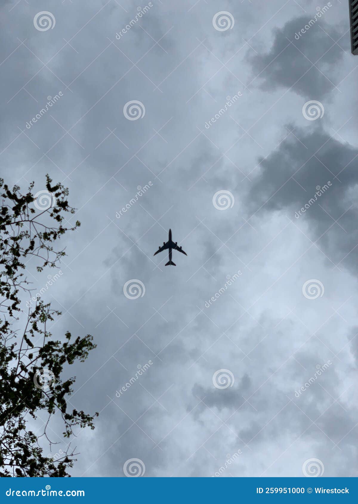Vertical Shot of a Plane Flying in the Cloudy Sky Stock Photo - Image ...