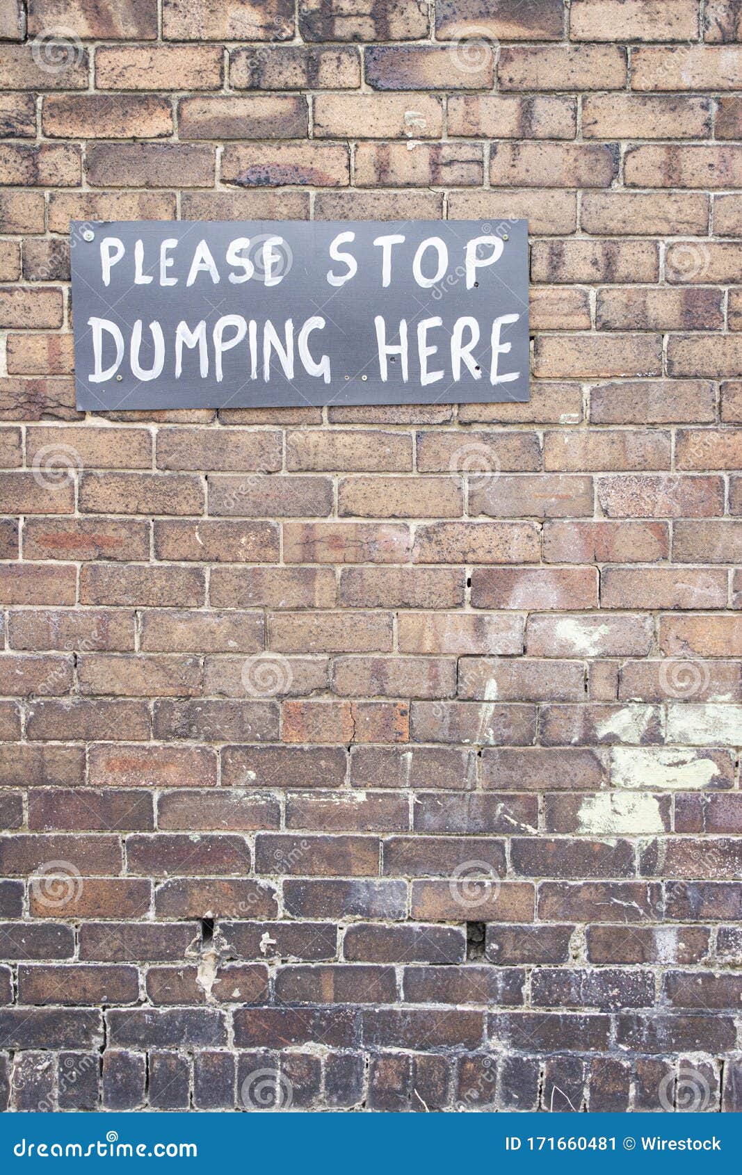 Vertical Shot of a Please Stop Dumping Here Sign on a Brick Wall Stock ...
