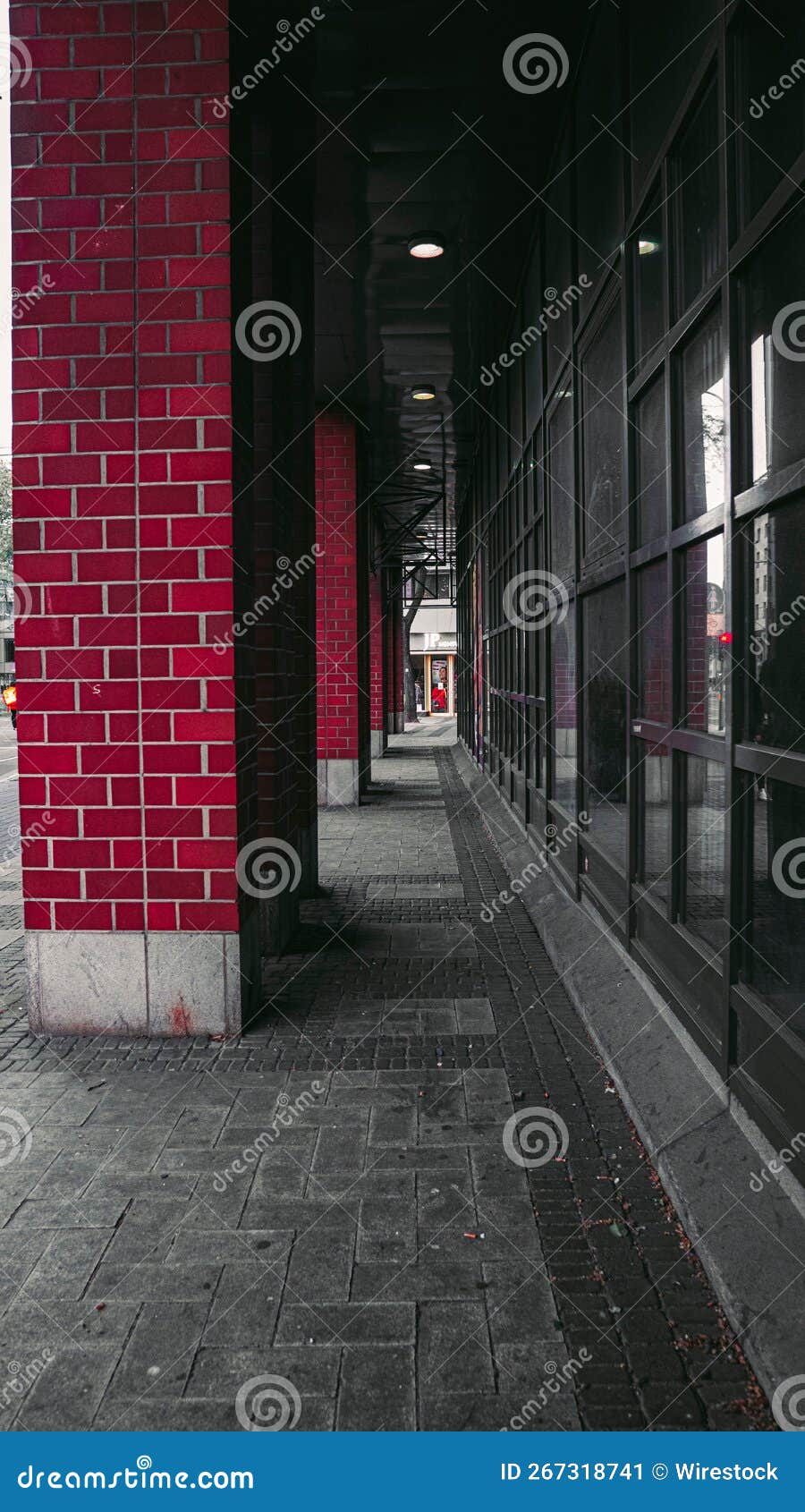 Vertical Shot of Red Brick Pillars in Front of a Building with Glass ...