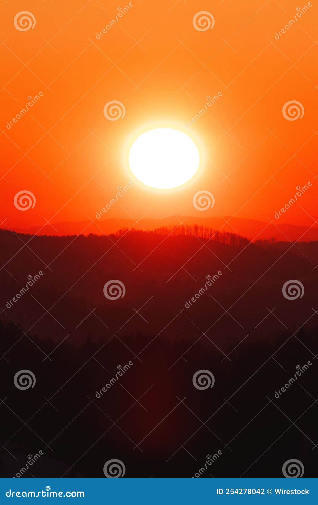 Vertical Shot of a Red Cloudless Sunset Above the Forest Mountains ...