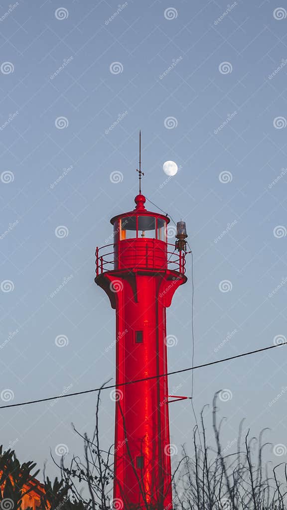 Vertical Shot of a Red Lighthouse with the Moon Above Stock Image ...