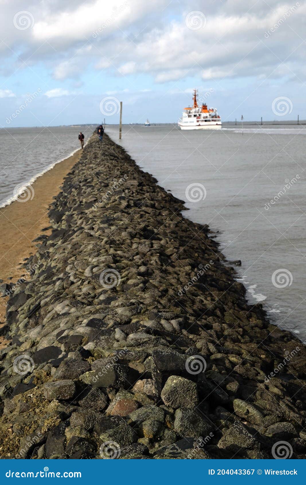 Vertical Shot of a Rocky Pathway at the Beach with a Sip on the ...
