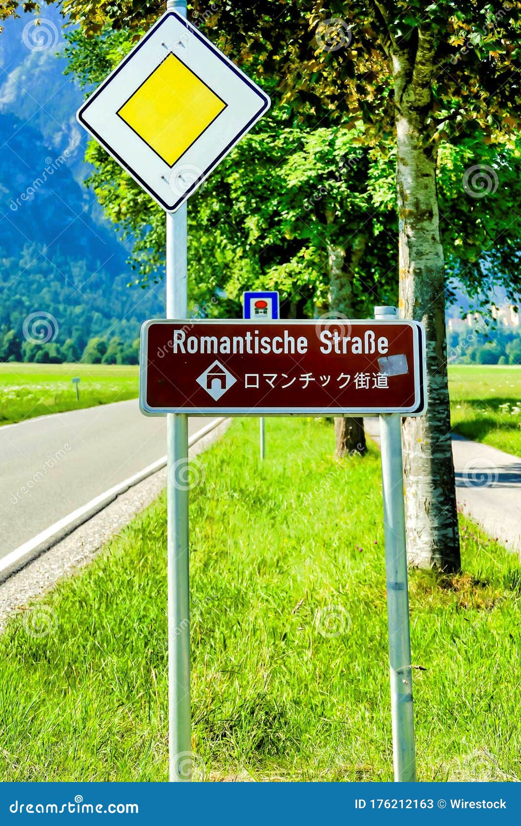 Vertical Shot of the Romantische Strasse Sign on the Side of the Road ...