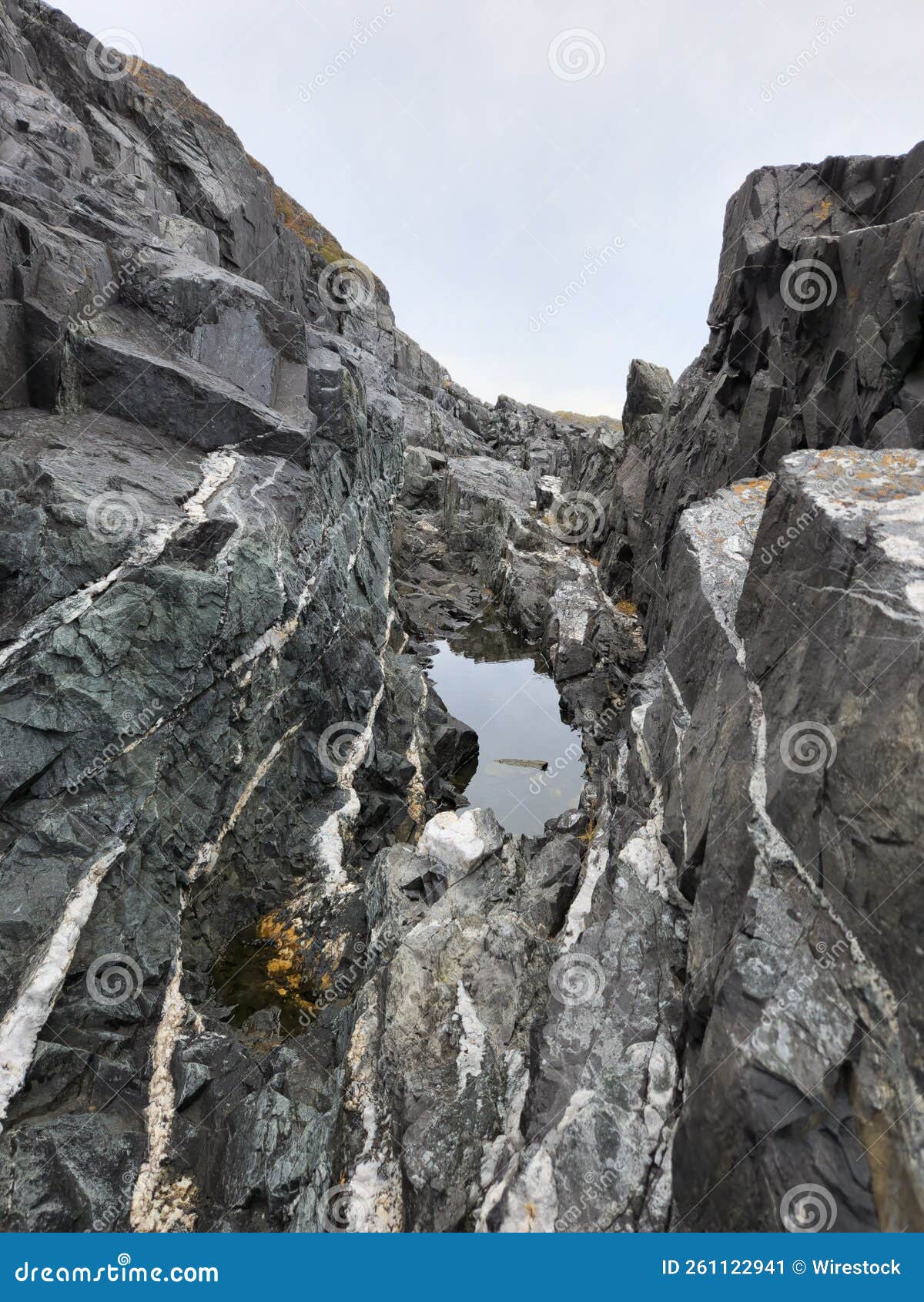 Vertical Shot of Rough Rocky Cliffs Under a Cloudy Sky Stock Image ...