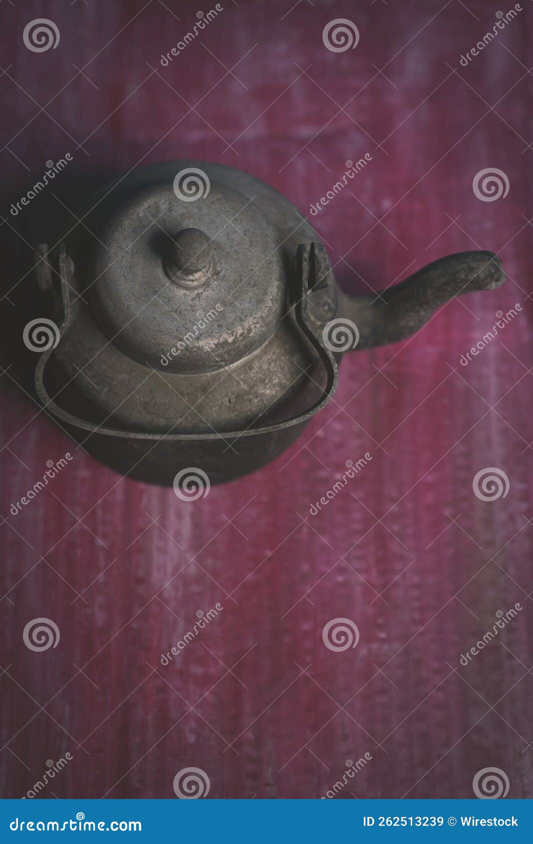 Vertical Shot of a Rusty Iron Teapot on a Rough Red Textile Background ...