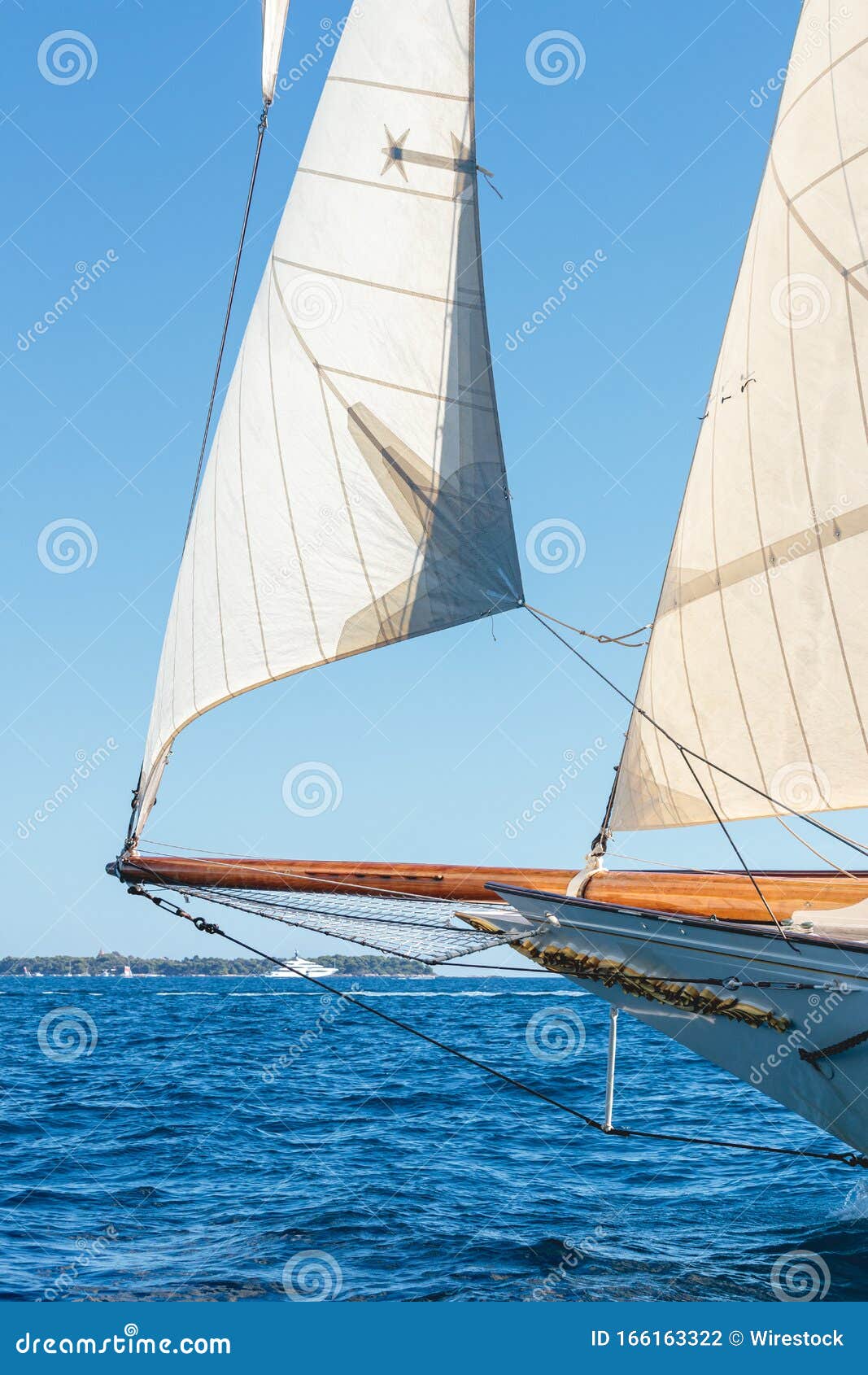 Vertical Shot of a Schooner Bow with White Sails on the Sea during ...