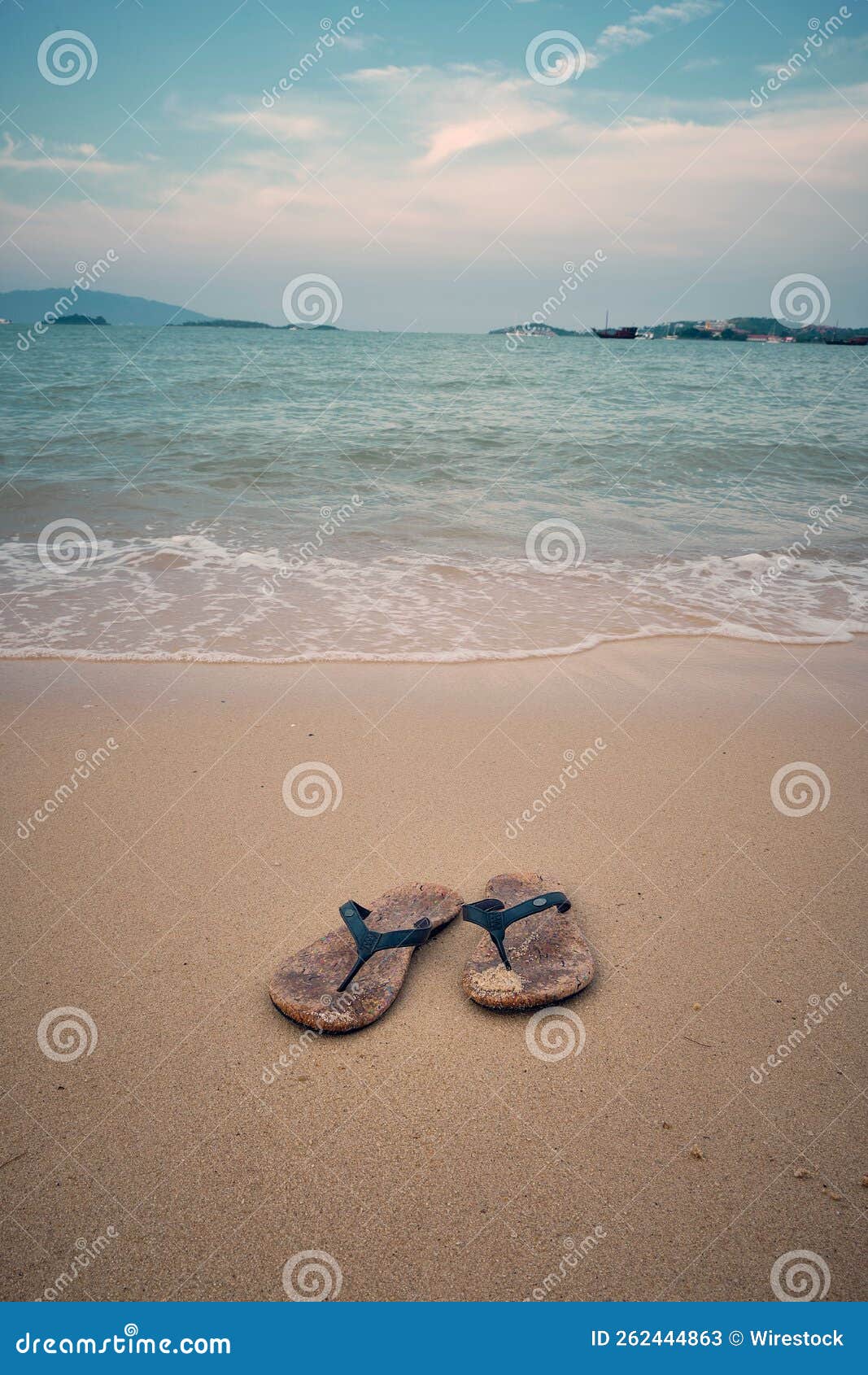 Vertical Shot of the Sea with a Pair of Slippers Isolated on the Beach ...