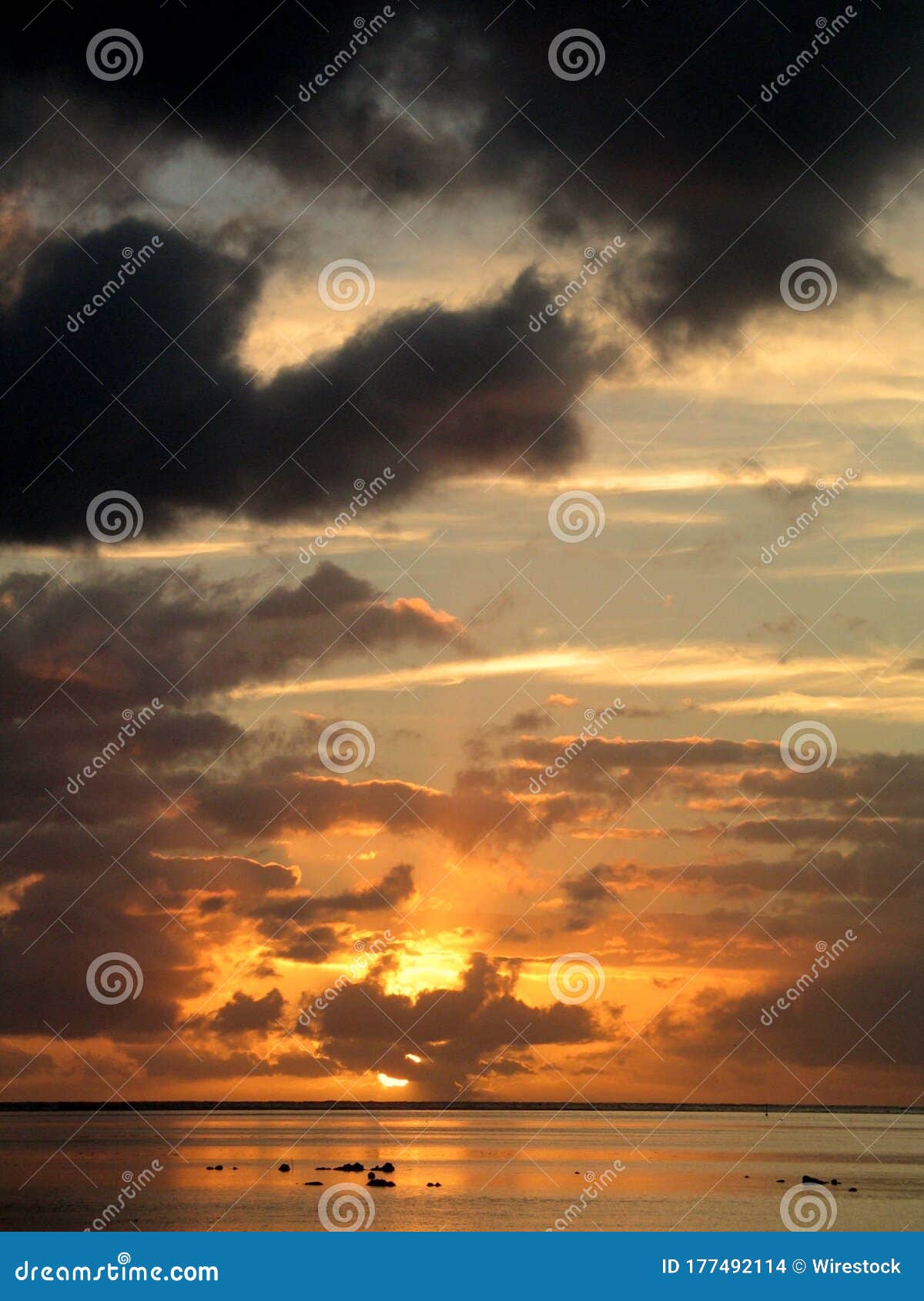 Vertical Shot of a Sea with the Sun Behind the Clouds in the Distance ...