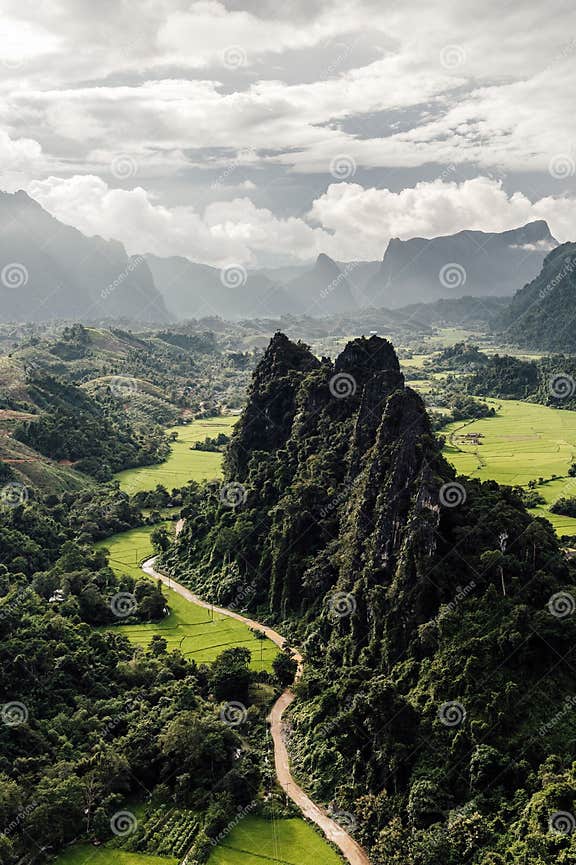 Vertical Shot of a Sharp Hill Covered with Trees and a Path beside it ...