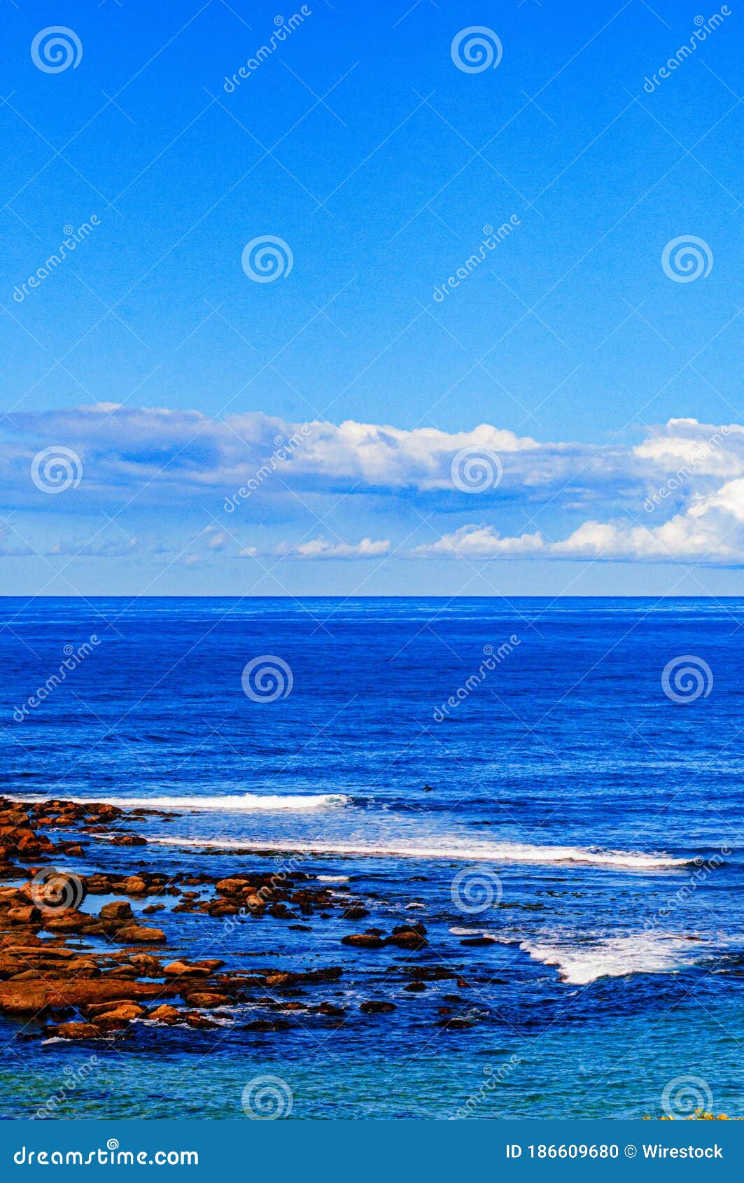 Vertical Shot of Small Rock Formations in the Beautiful Blue Sea Stock ...