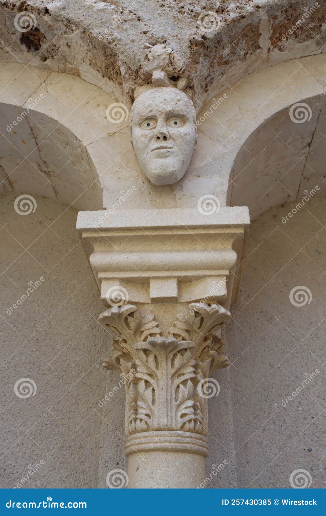 Vertical Shot of a Stone Face on a Column with Two Vaults of an Old ...