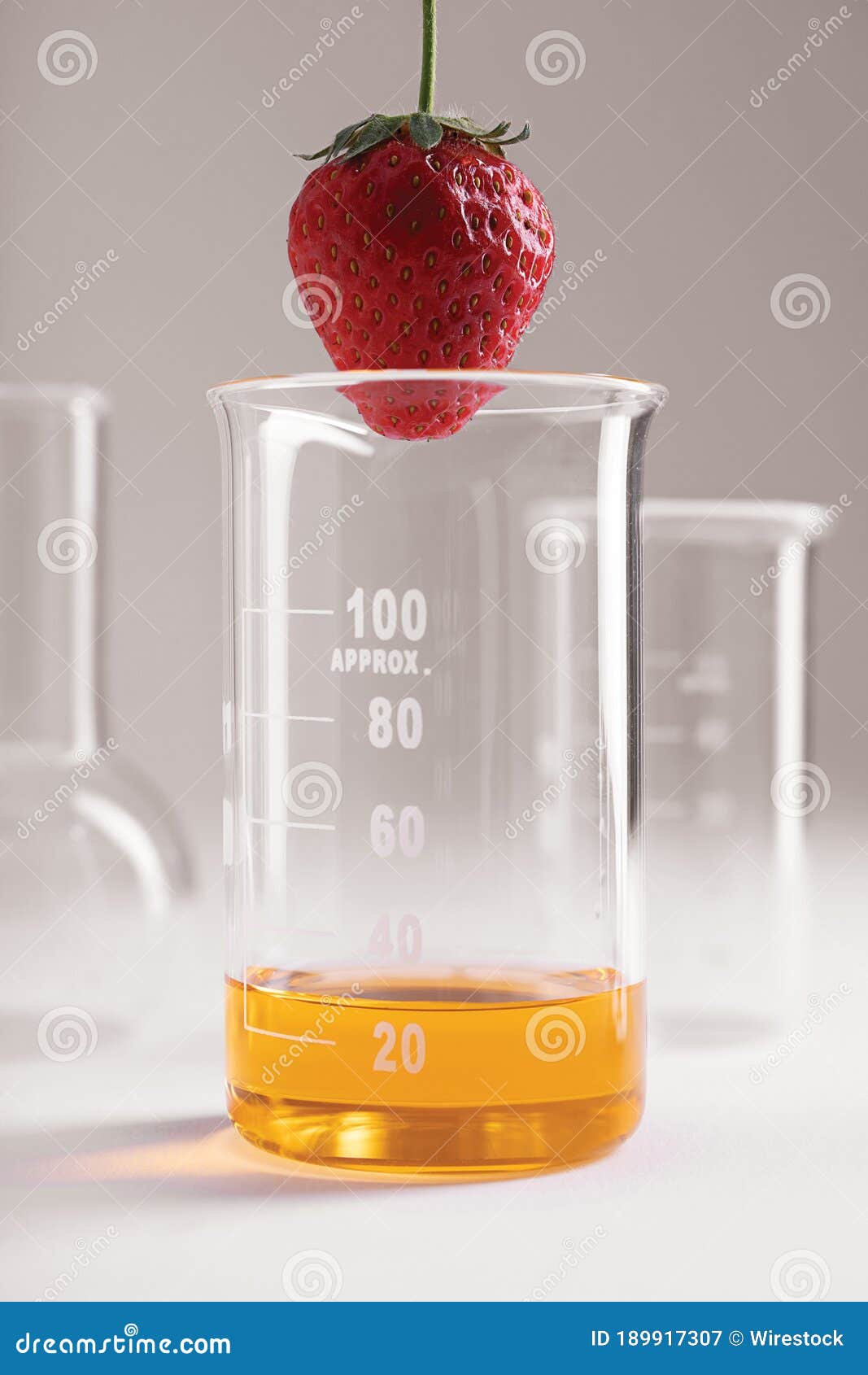 Vertical Shot Of A Strawberry Over A Beaker With Yellow Liquid For DNA ...