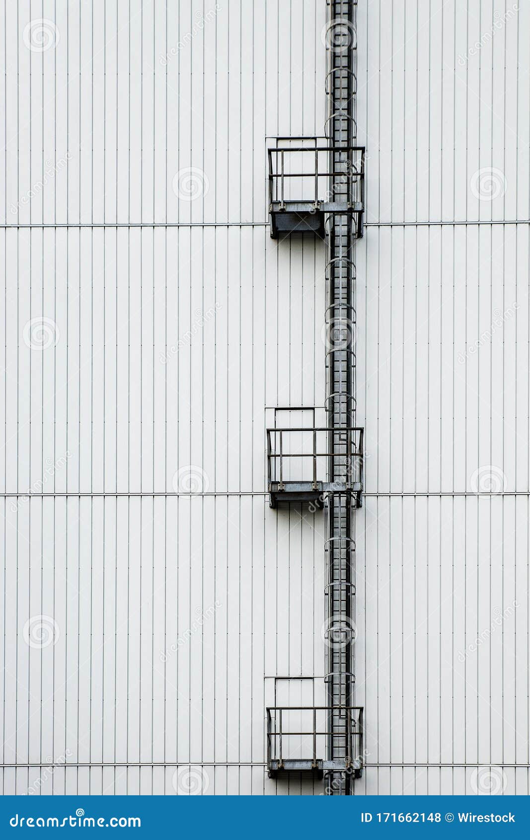 Vertical Shot of a Tall White Building with a Ladder on the Side Stock ...