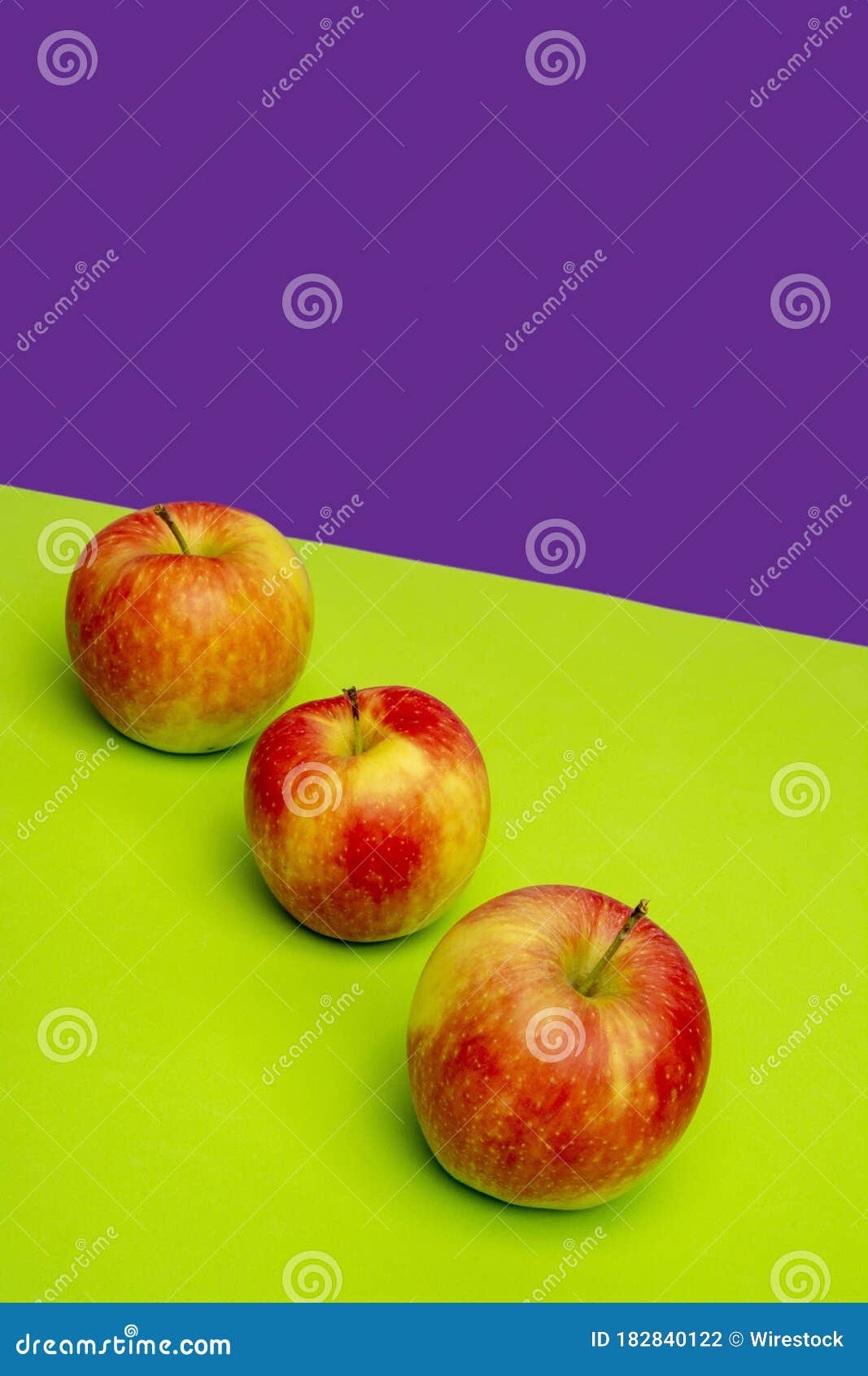 Vertical Shot of Three Apples Put on a Colorful Surface Stock Photo ...