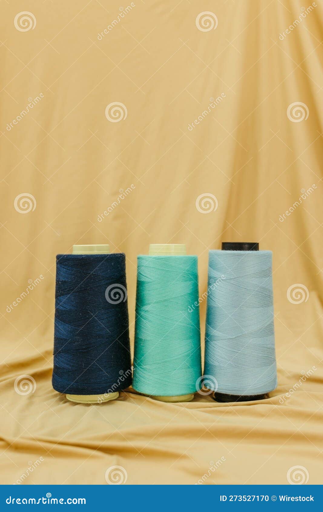 A Vertical Shot of Three Different Colored Spool Threads Stock Photo ...