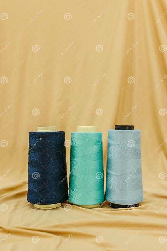 A Vertical Shot of Three Different Colored Spool Threads Stock Photo ...