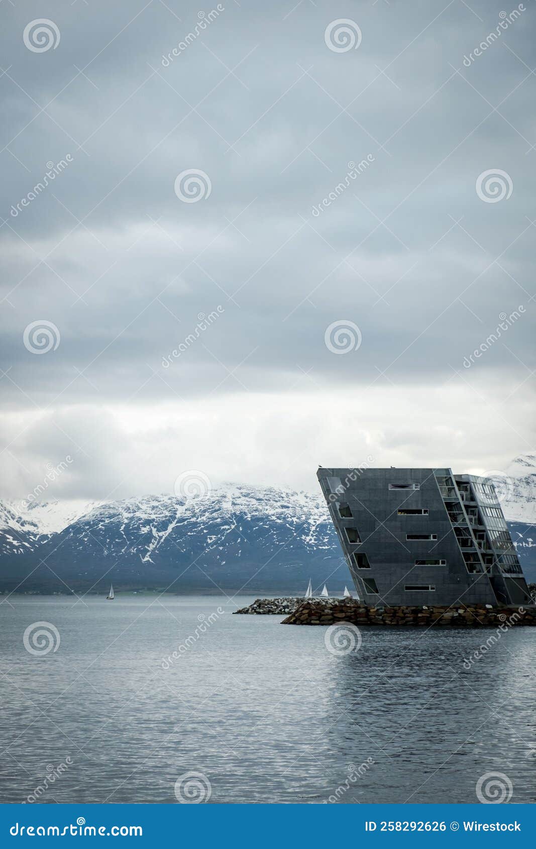 Vertical Shot of a Tilted Apartment Building with Beautiful Mountains ...
