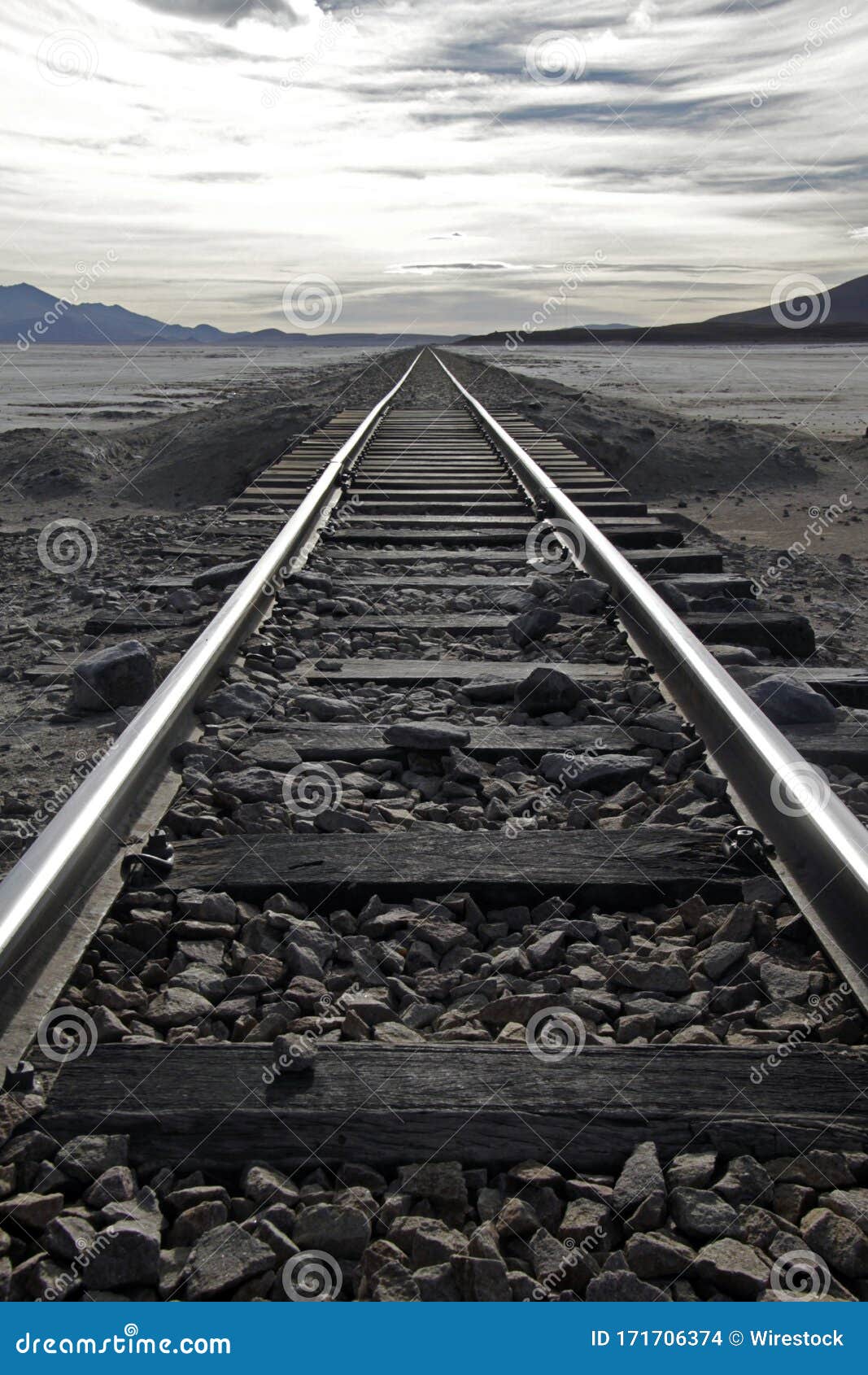 Vertical Shot of Train Tracks Under a Cloudy Sky Stock Photo - Image of ...