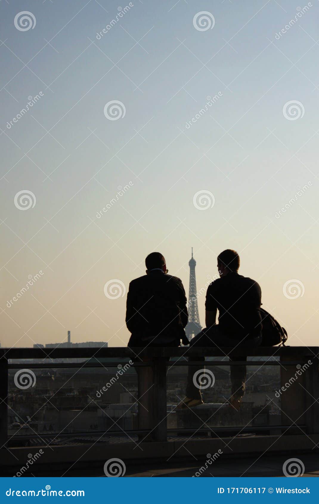 Vertical Shot of Two People Sitting on the Balcony Railing in Paris ...