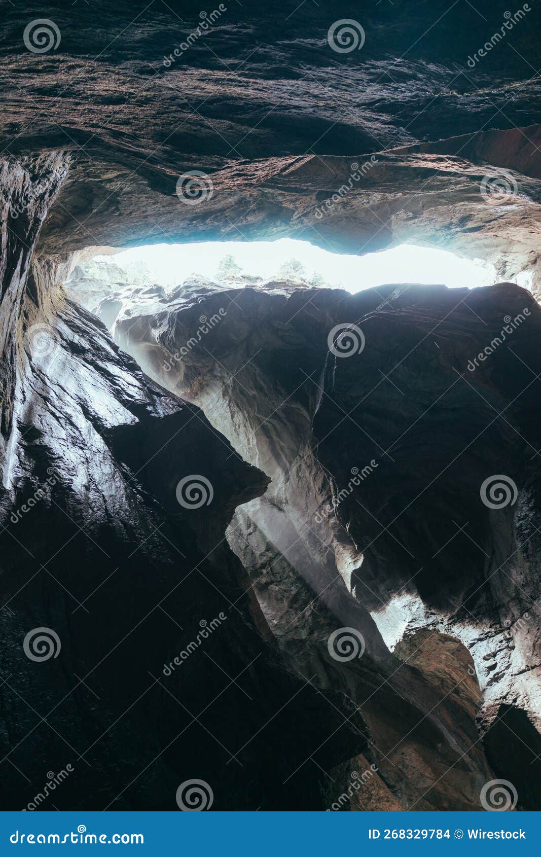 Vertical Shot of a View from Inside a Rugged Cave Looking Out through a ...