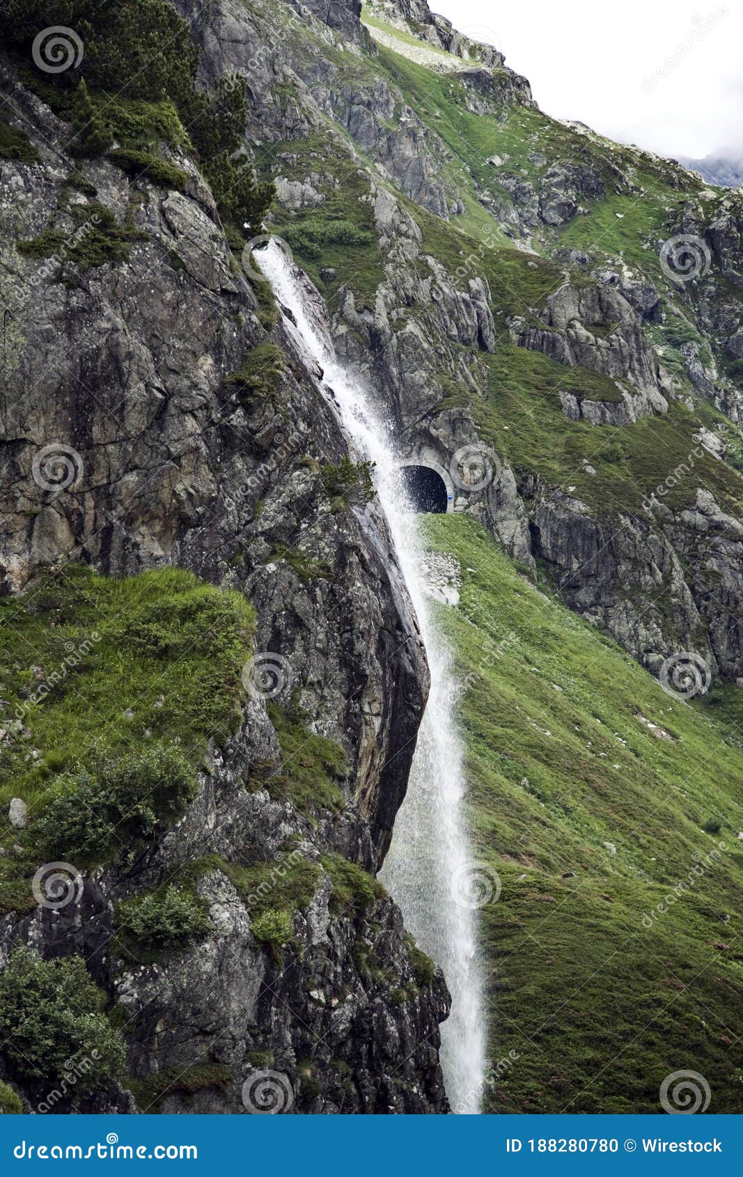Vertical Shot of a Waterfall with a Road Tunnel in a Mountain Stock ...