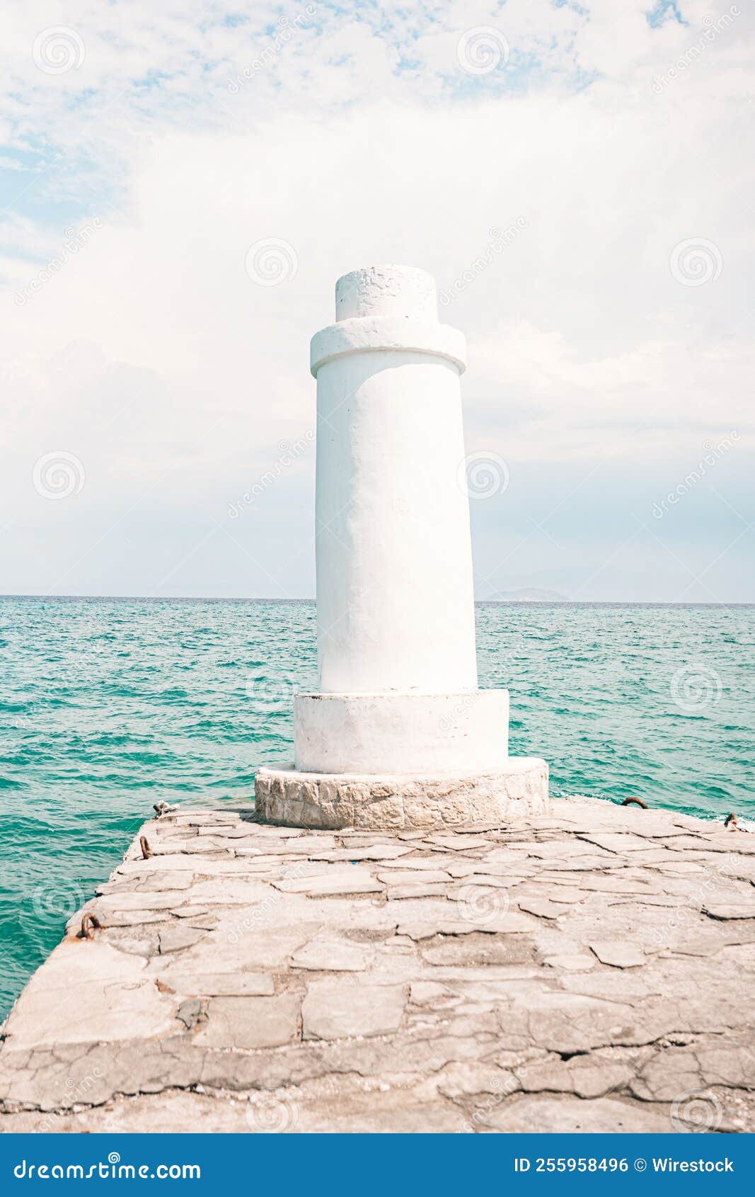 Vertical Shot of a White Lighthouse Tower Standing on a Breakwater ...