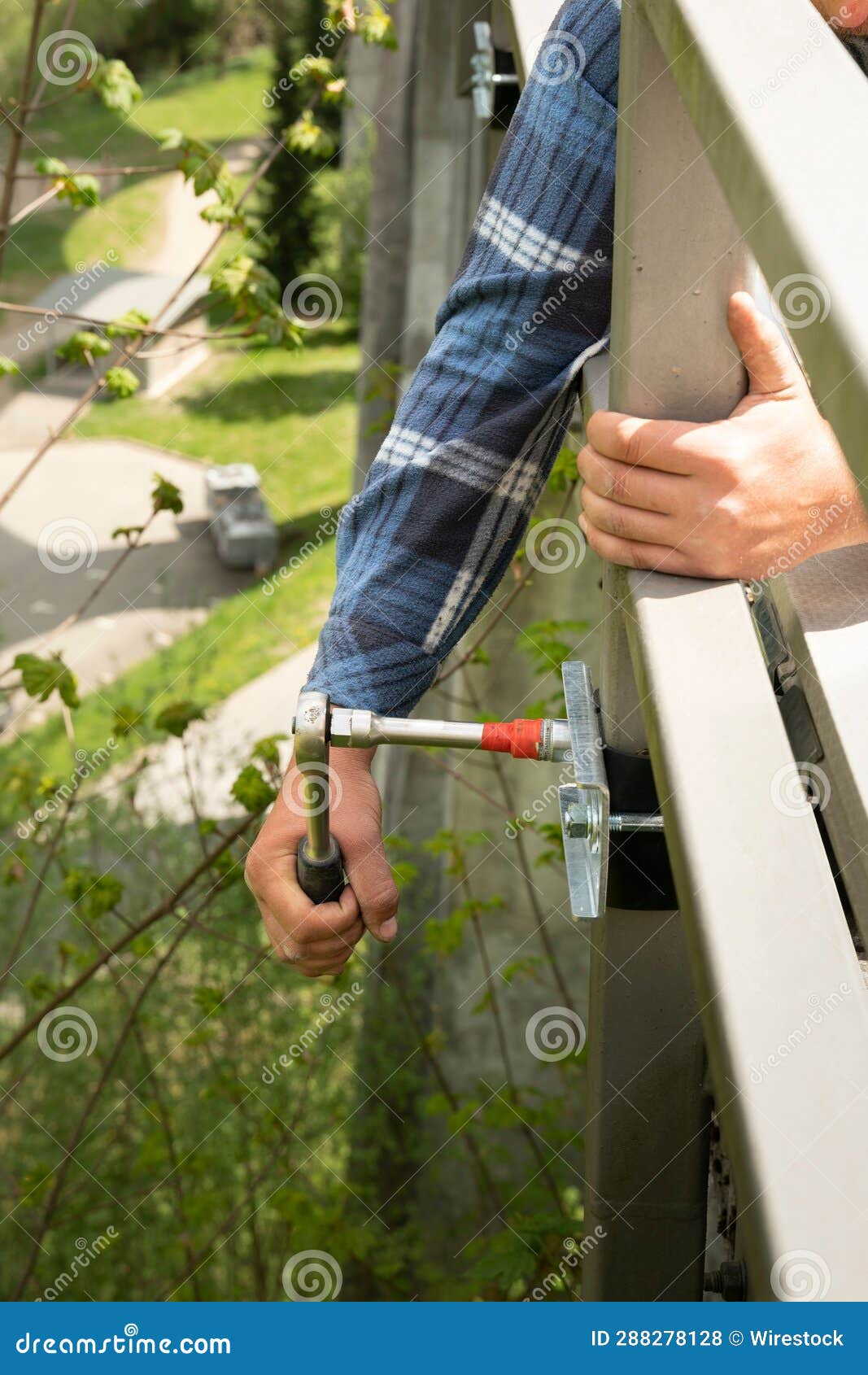 Vertical Shot of a Workman Installing a Cable Duct on a Bridge Railing ...