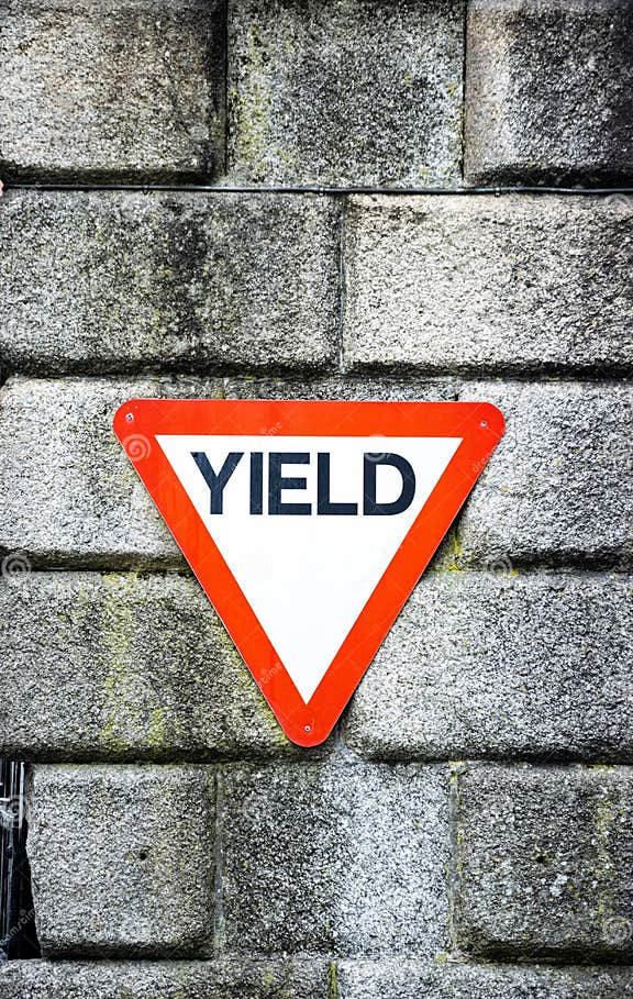 Vertical Shot of a Yield Triangle Sign on a Wall Stock Photo - Image of ...