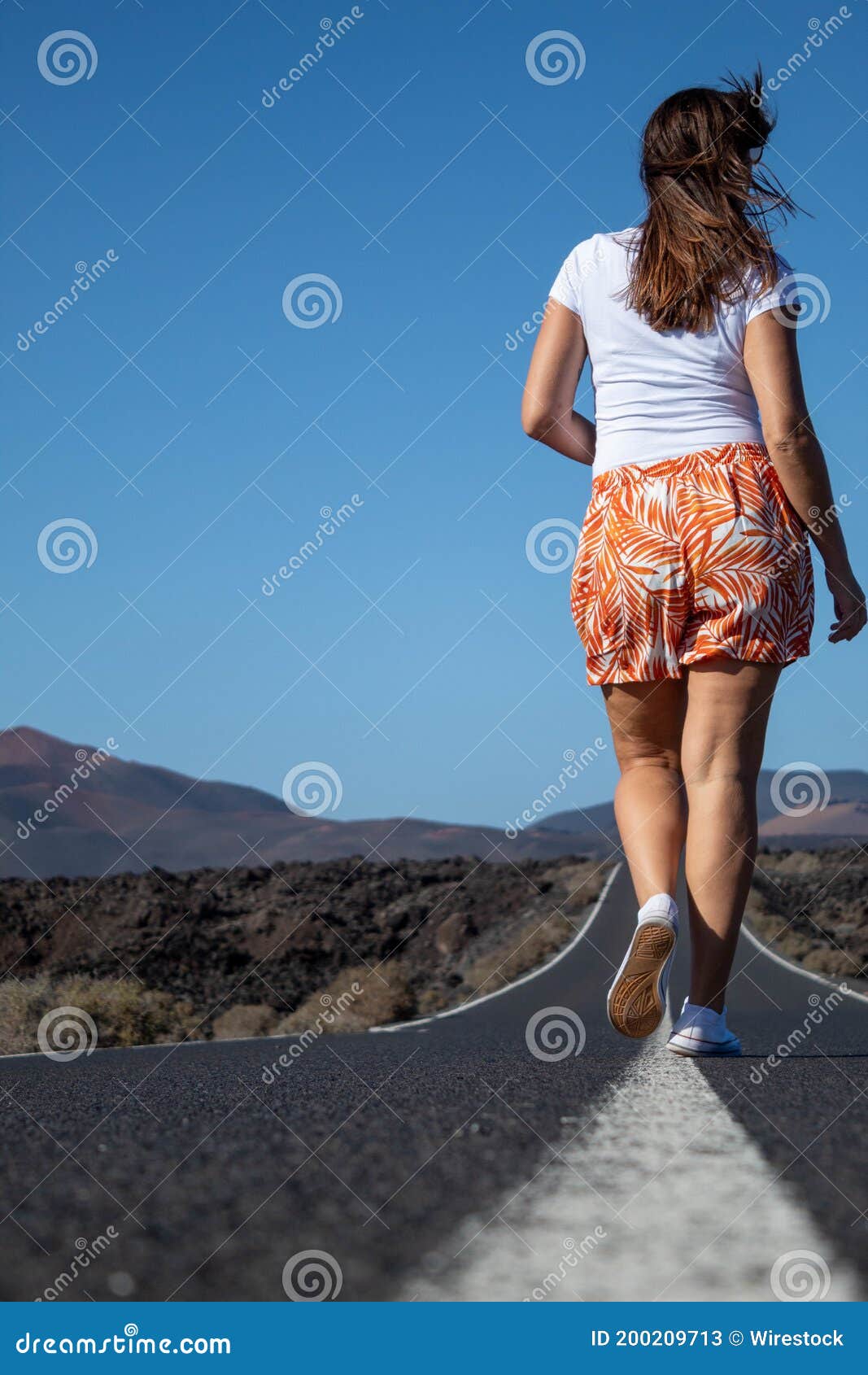 Vertical Shot of a Young Female Walking on the Road Stock Image - Image ...