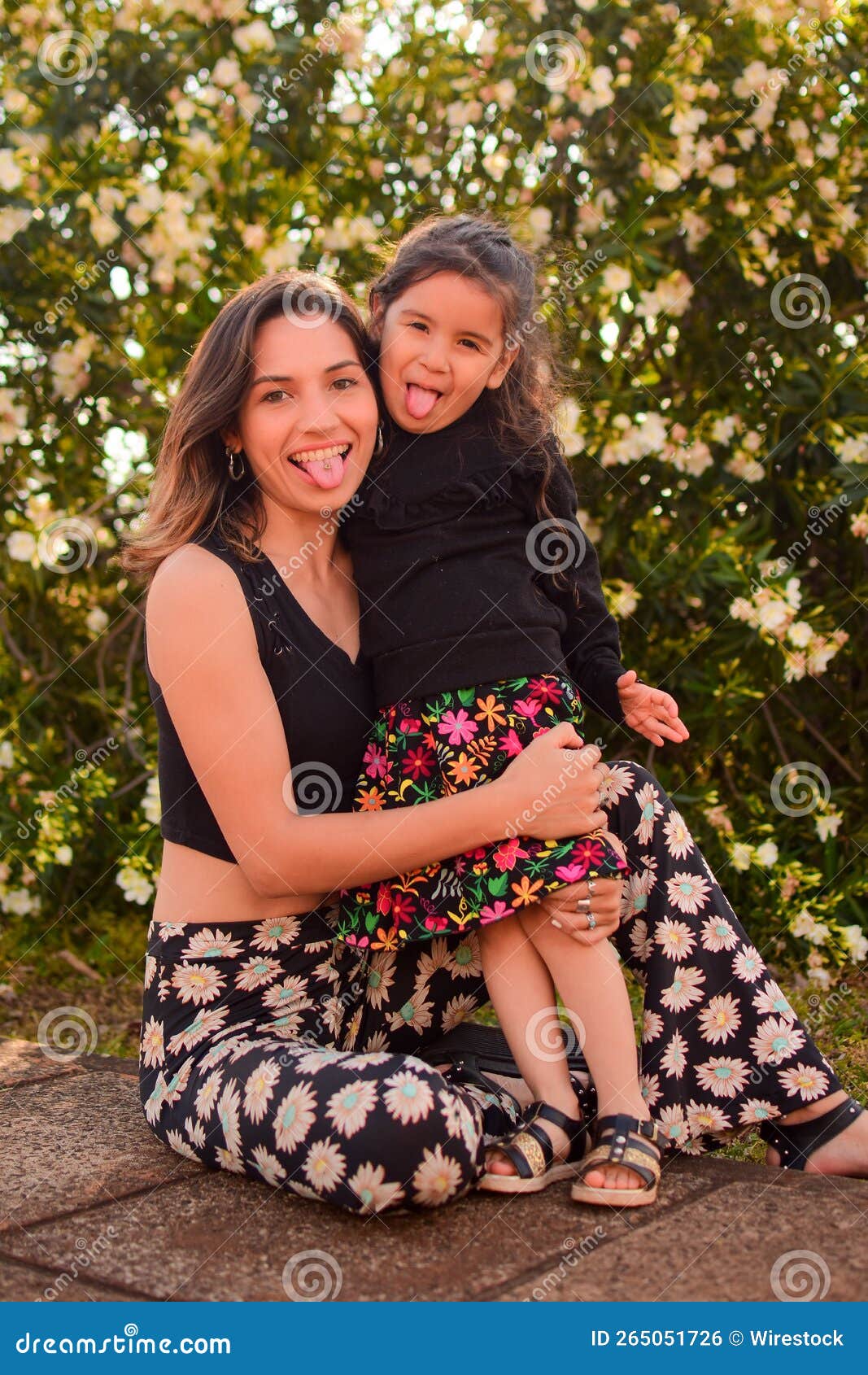 Vertical Shot of a Young Kid with Her Mom Posing in a Park in Daylight ...
