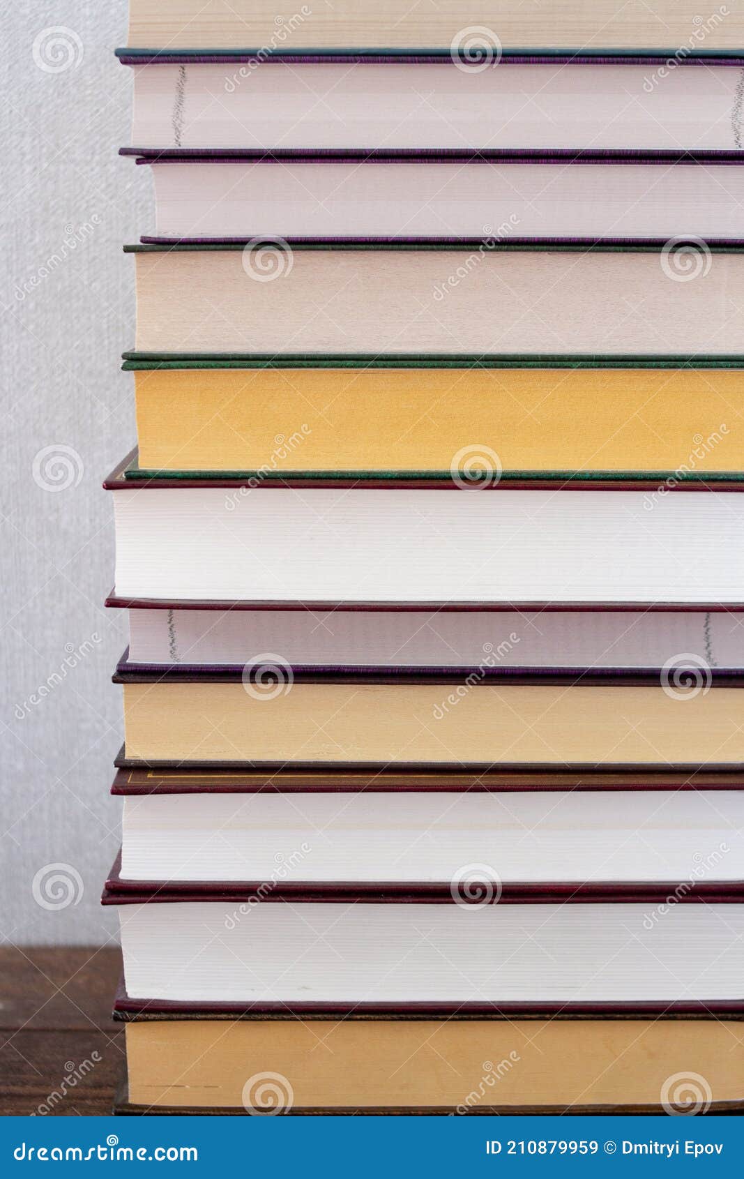 A Vertical of Stack of Books on a Wooden Shelf and a Gray Background ...
