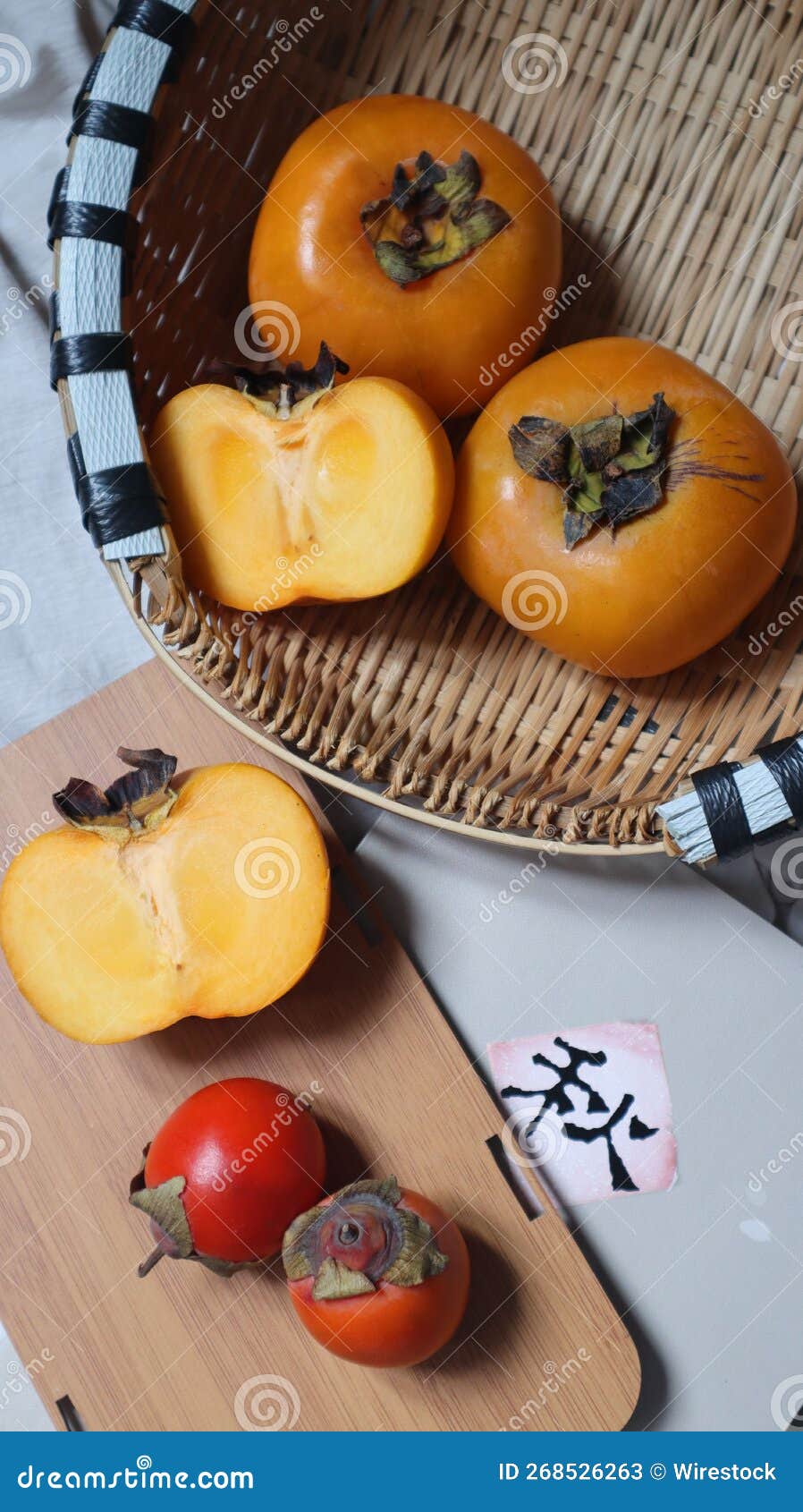 Vertical Top View of a Basket with Persimmons and a Halved Persimmon on ...