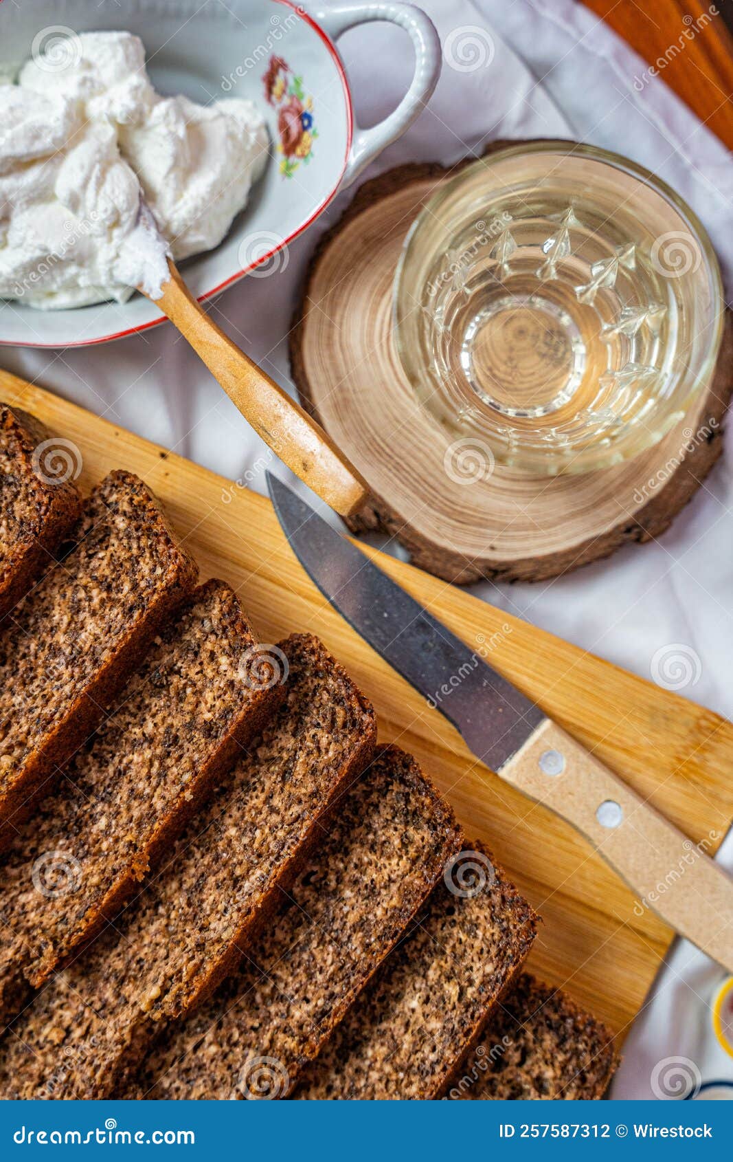 Vertical Top View of Sliced Walnut Bread, Sour Cream, and a Glass on ...