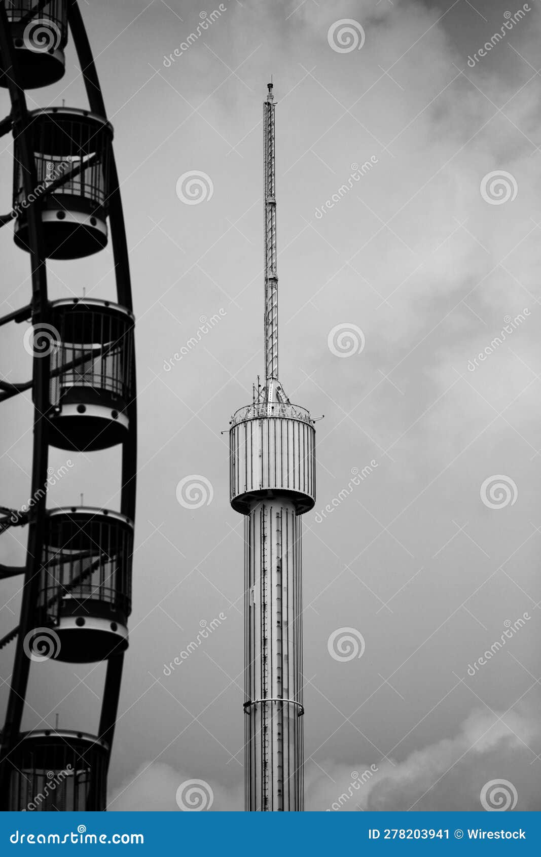 Vertical of a Tower Near a Ferris Wheel in Grayscale Stock Image ...