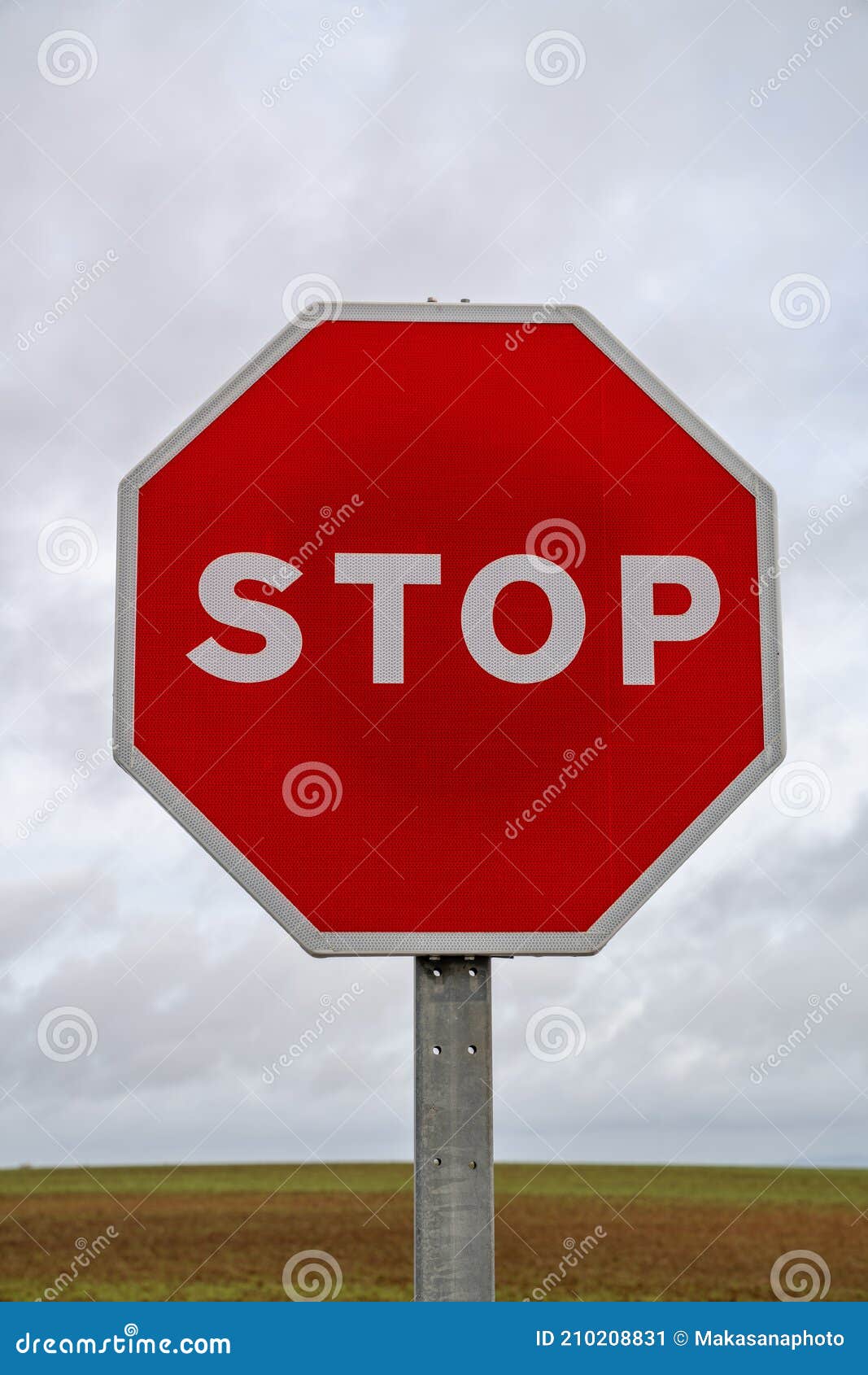 Vertical View of a Bright Red Stop Sign with a Gray Overcast Sky Behind ...