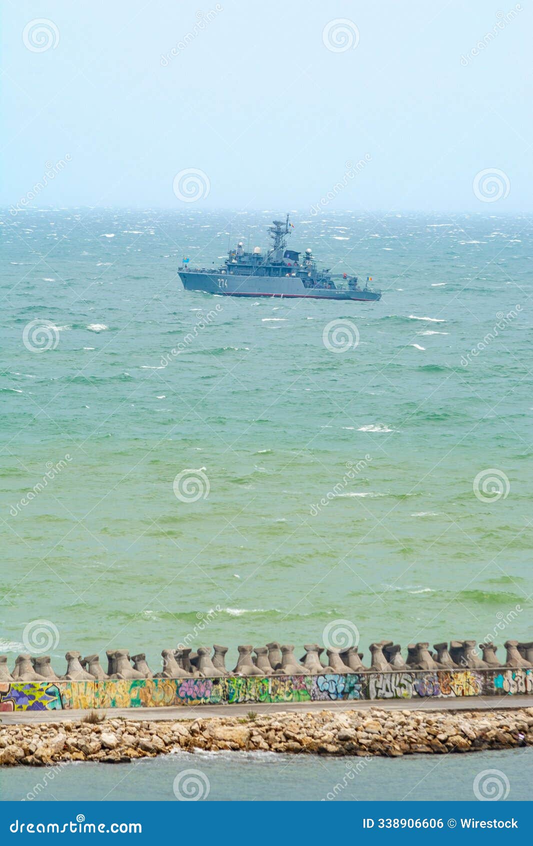 Vertical View of Concrete Blocks and Breakwater, with a Ship Sailing in ...