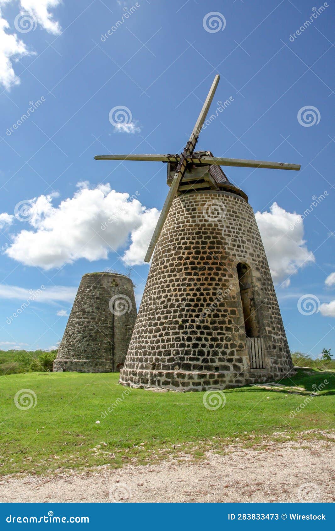 Vertical View of Two Rustic, Brick Windmills in a Green Field Stock ...