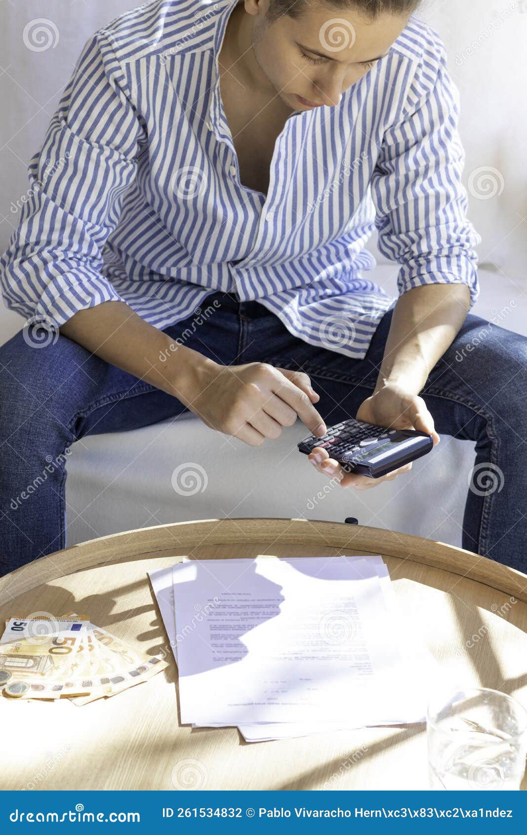 Vertical View of Young Man Sitting in the Couch Doing Calculations and ...