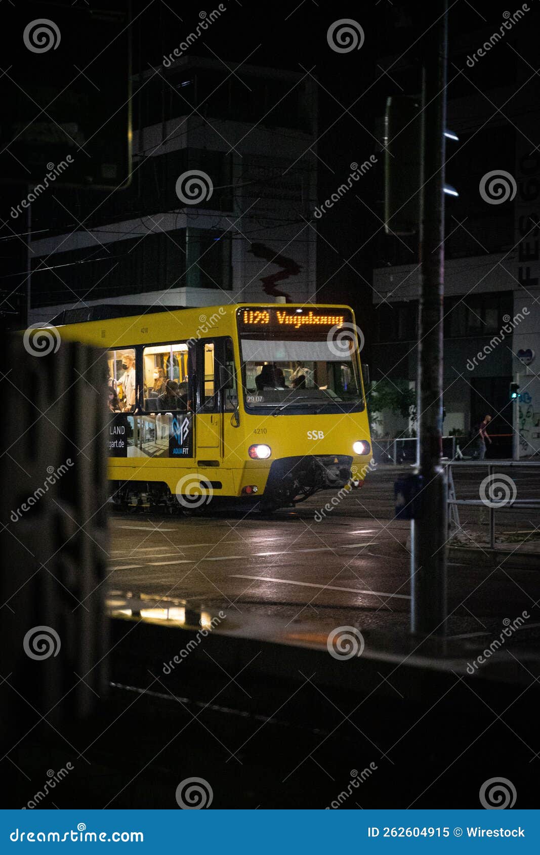 Vertical of a Yellow Train in Front of Buildings in the Evening in ...