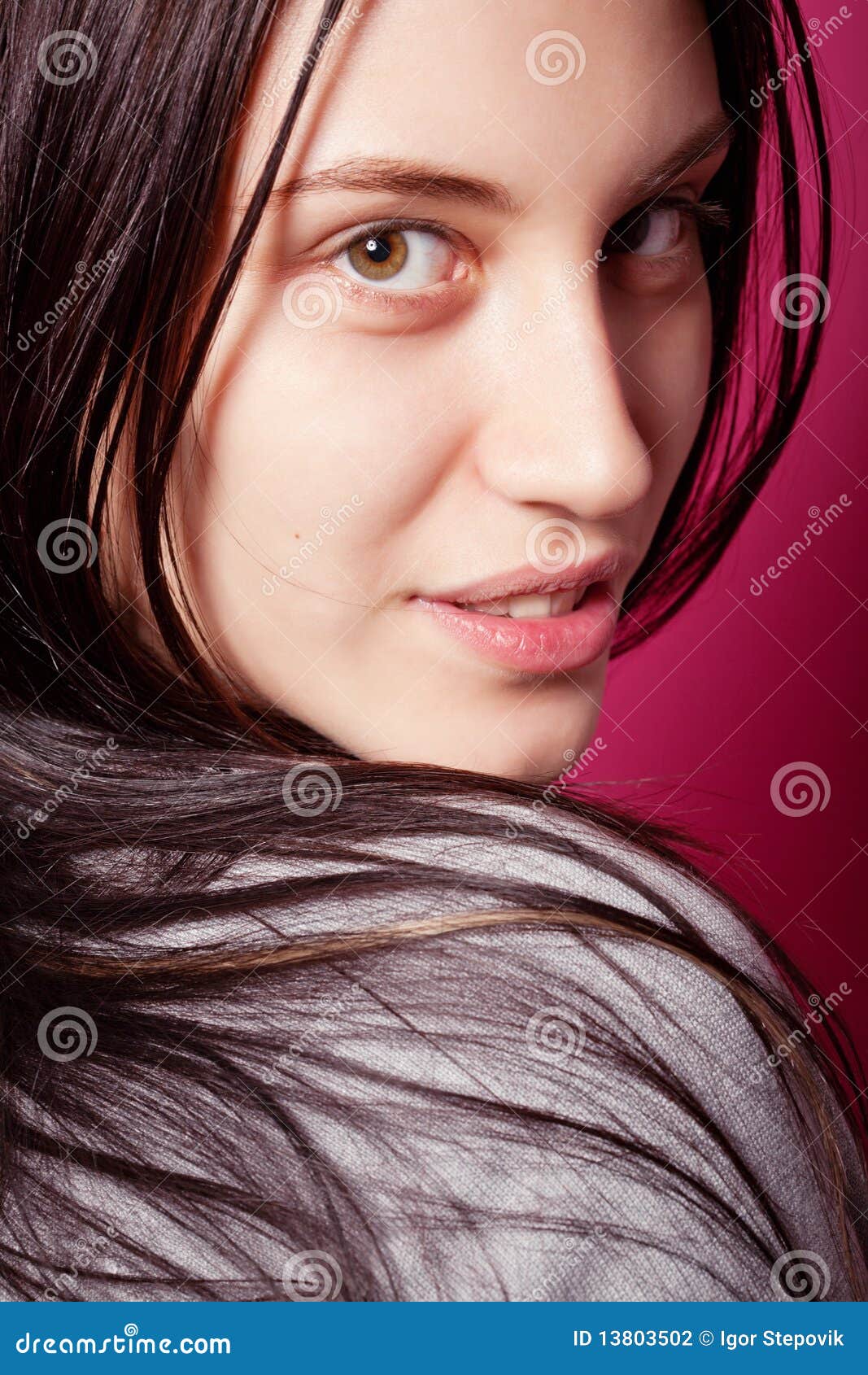 Verticale De Fille De Brunette Avec Le Long Cheveu Au Dessus Du Rose