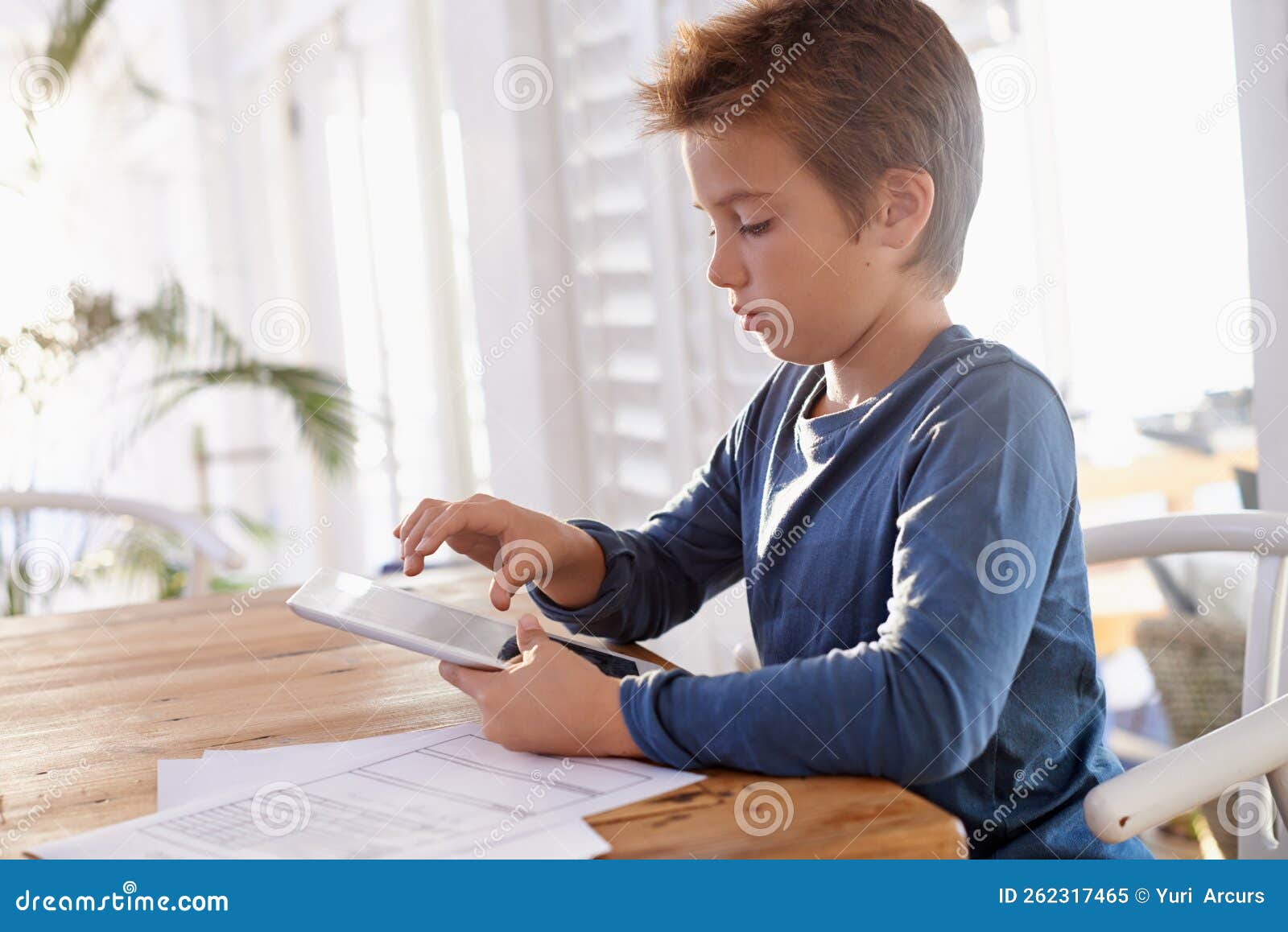 A Very Efficient Homework Session. a Young Boy Using a Digital Tablet ...
