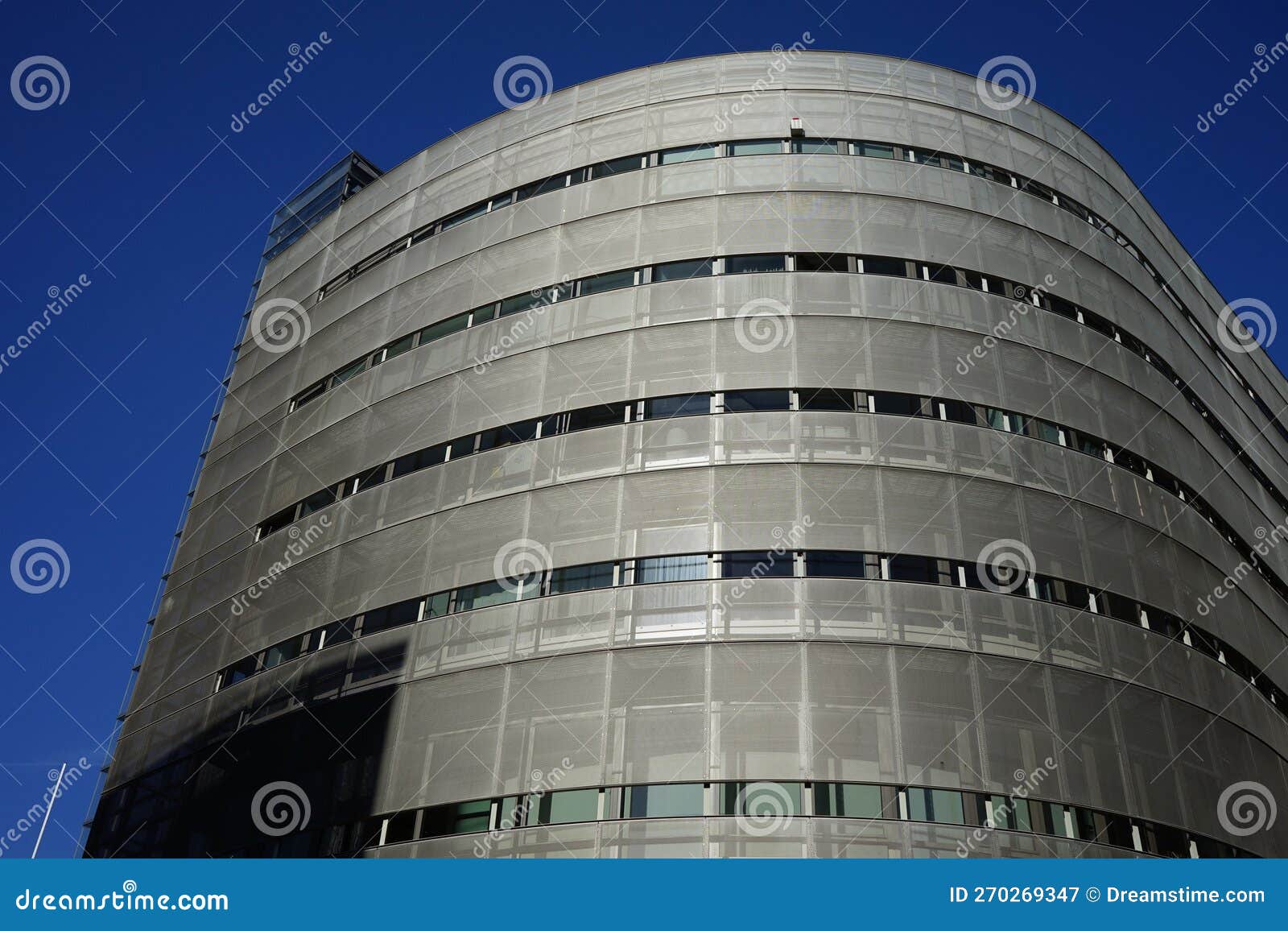 This is a Very Large, Curved Building with Windows and a Clock Stock ...