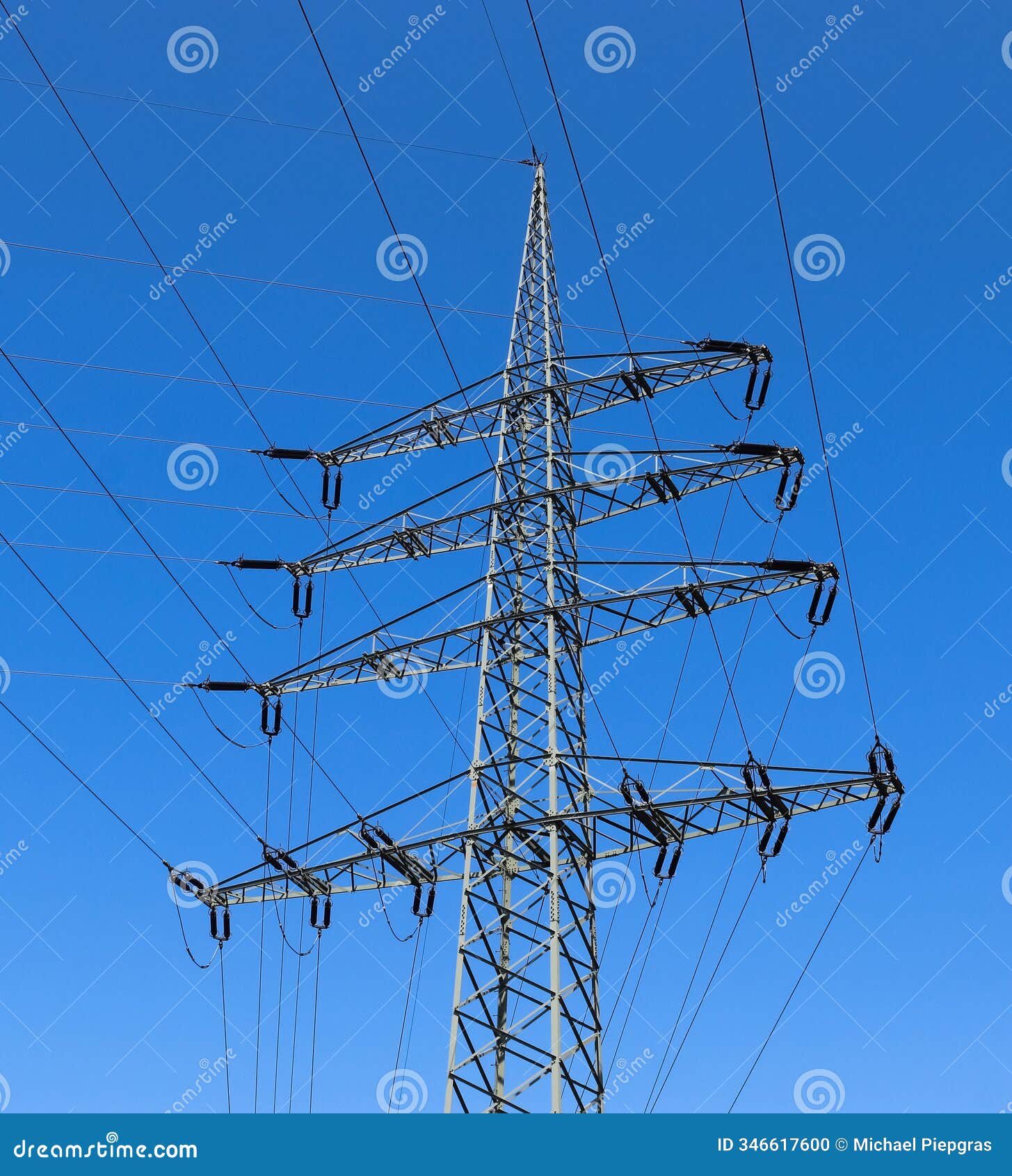 A Very Large Electricity Pylon with Many Cables in Front of a Blue Sky ...