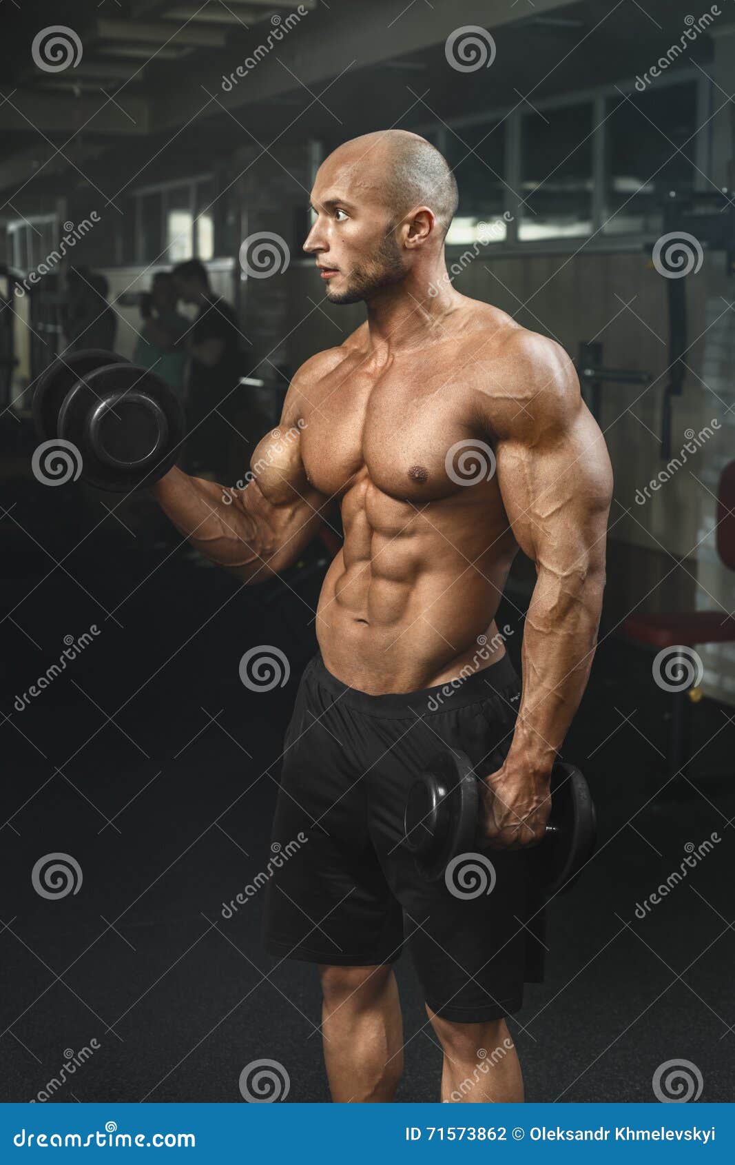 Very Powerfull Athletic Guy Working in Gym with Dumbbells Stock Photo ...