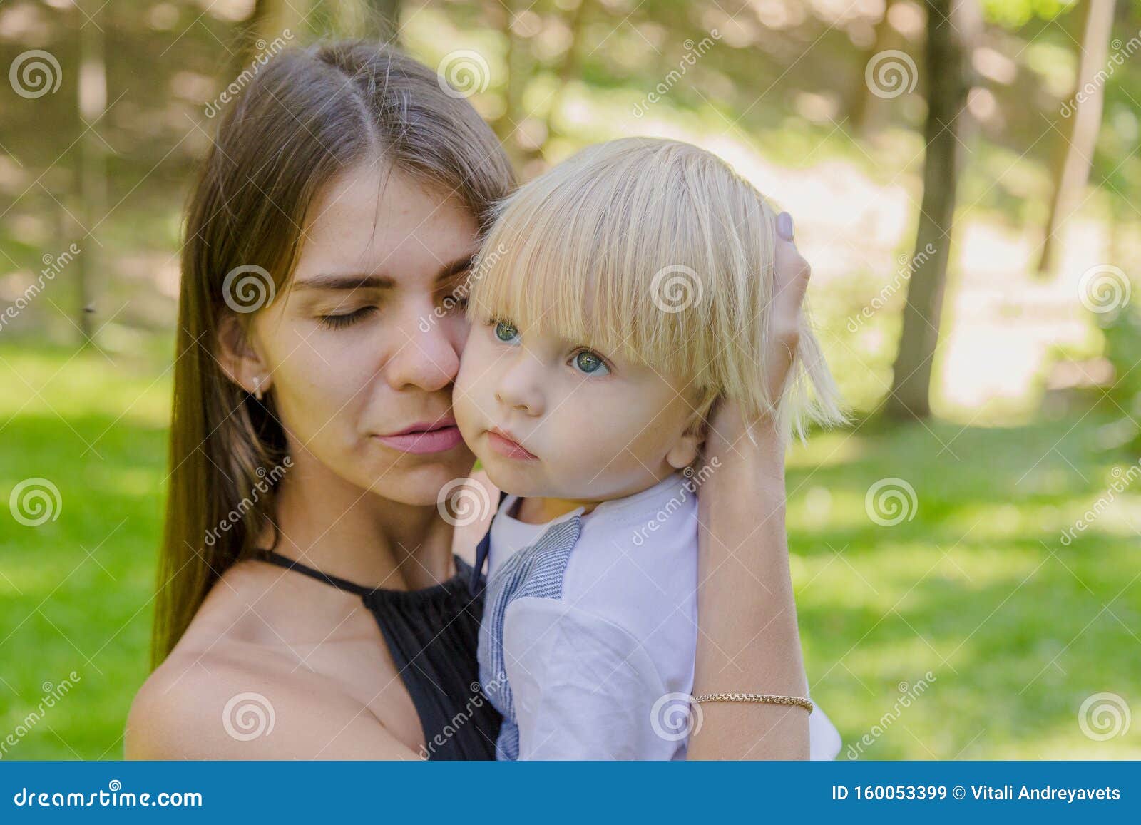 Very Sad Mom and Little Son in Her Arms in the Park. Stock Image ...