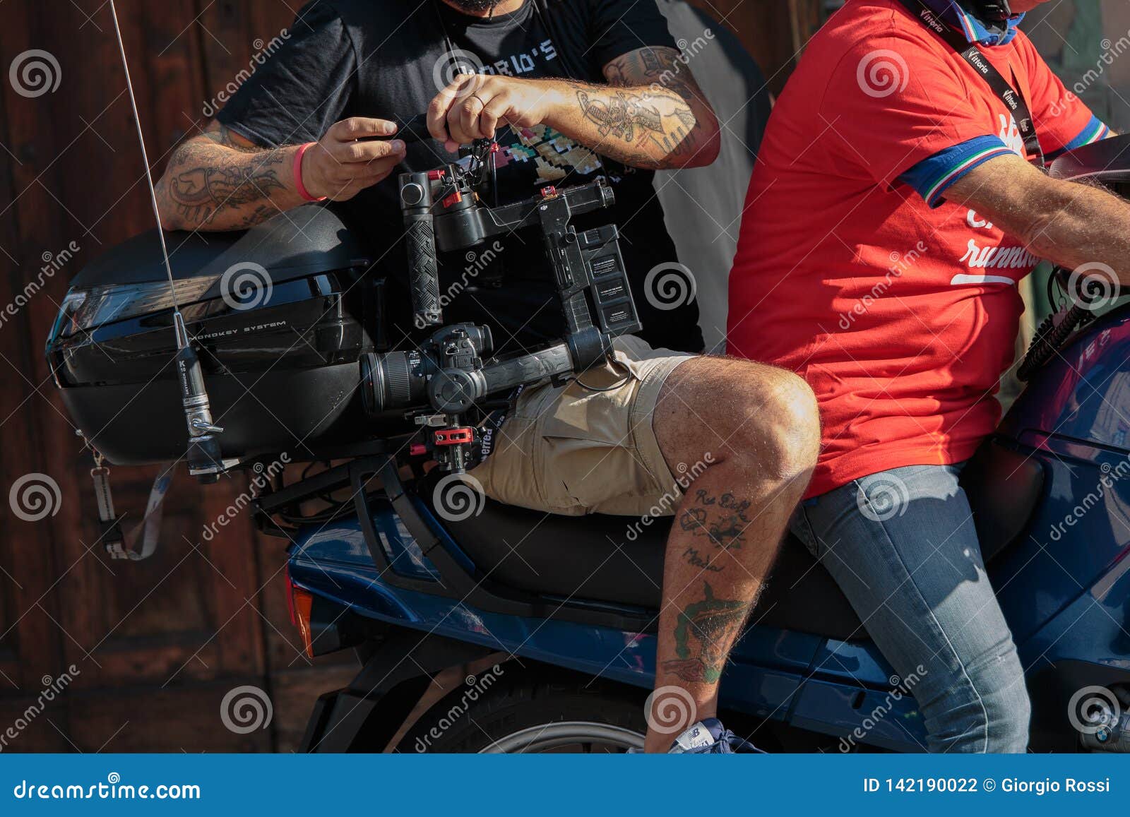Video Camera Operator on a Motorcycle with a Camera while Filming a ...