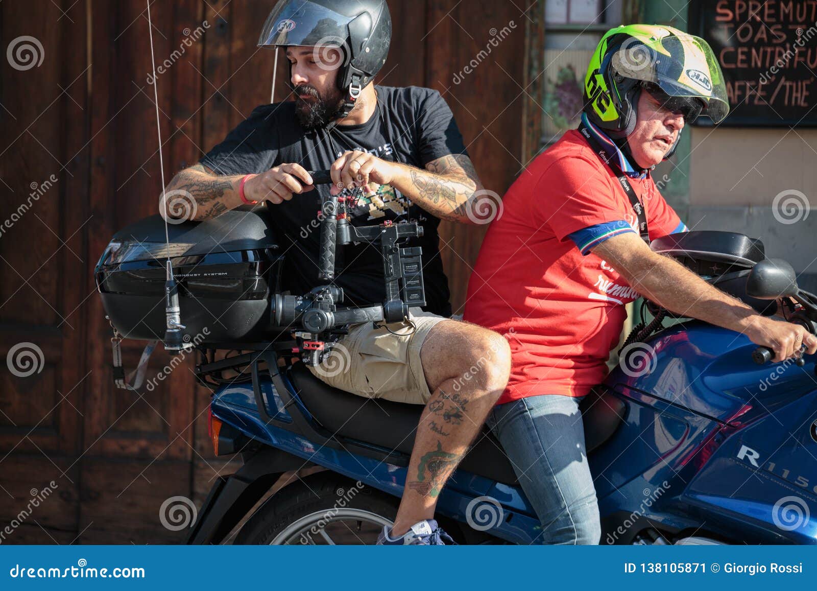 Video Camera Operator on a Motorcycle with a Camera while Filming a ...