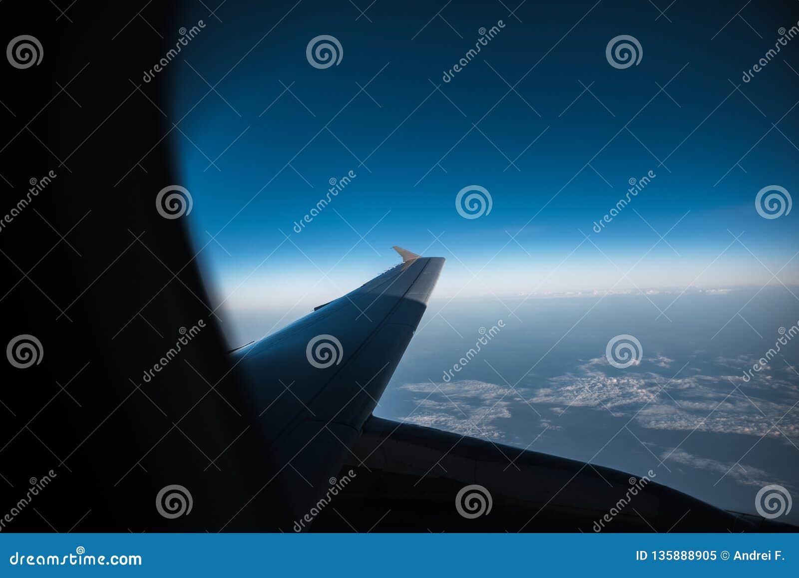 View of Airplane Wing through Window. Flying Above the Clouds Stock ...