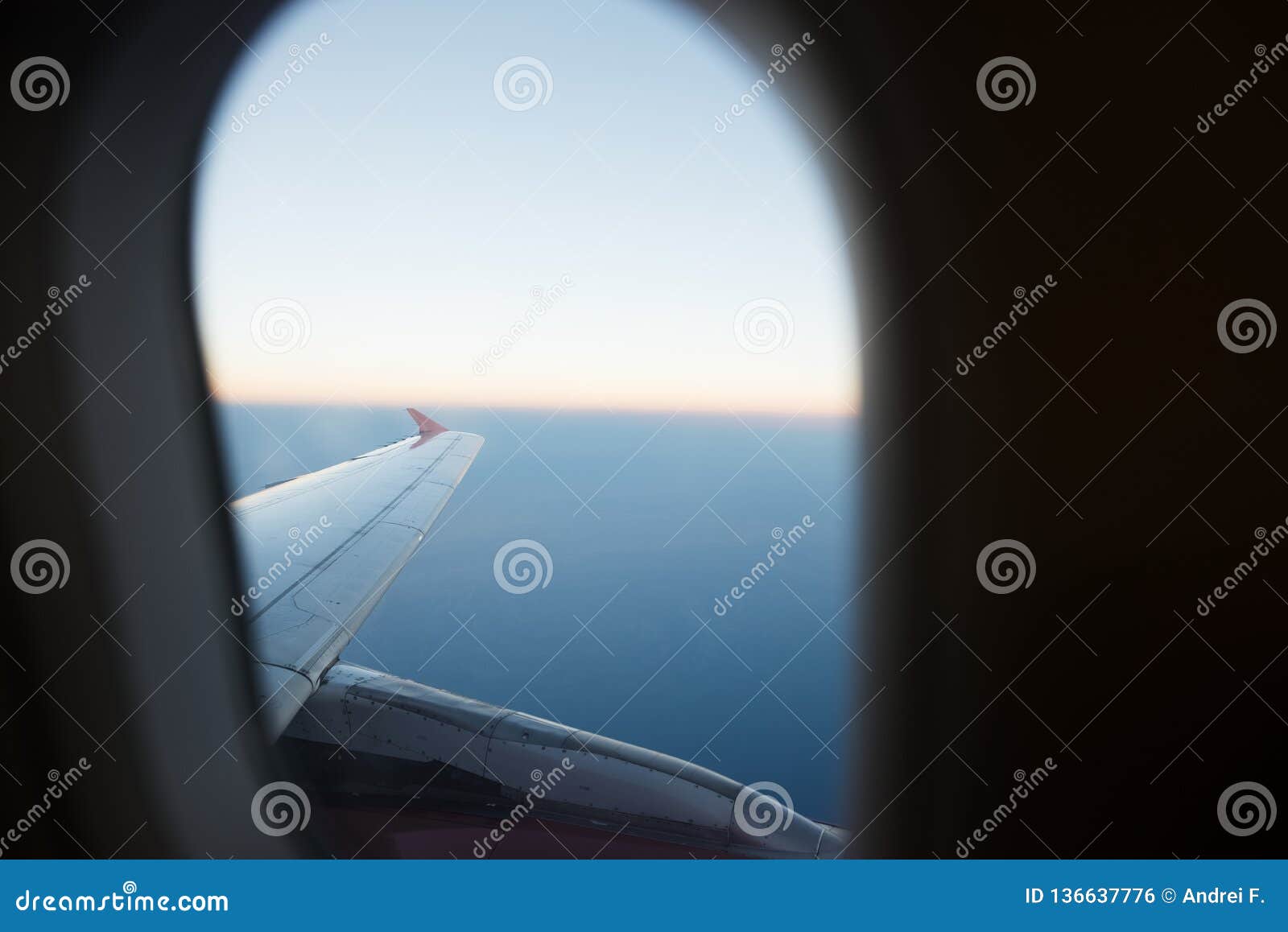 View of Airplane Wing through Window. Flying Above the Clouds Stock ...